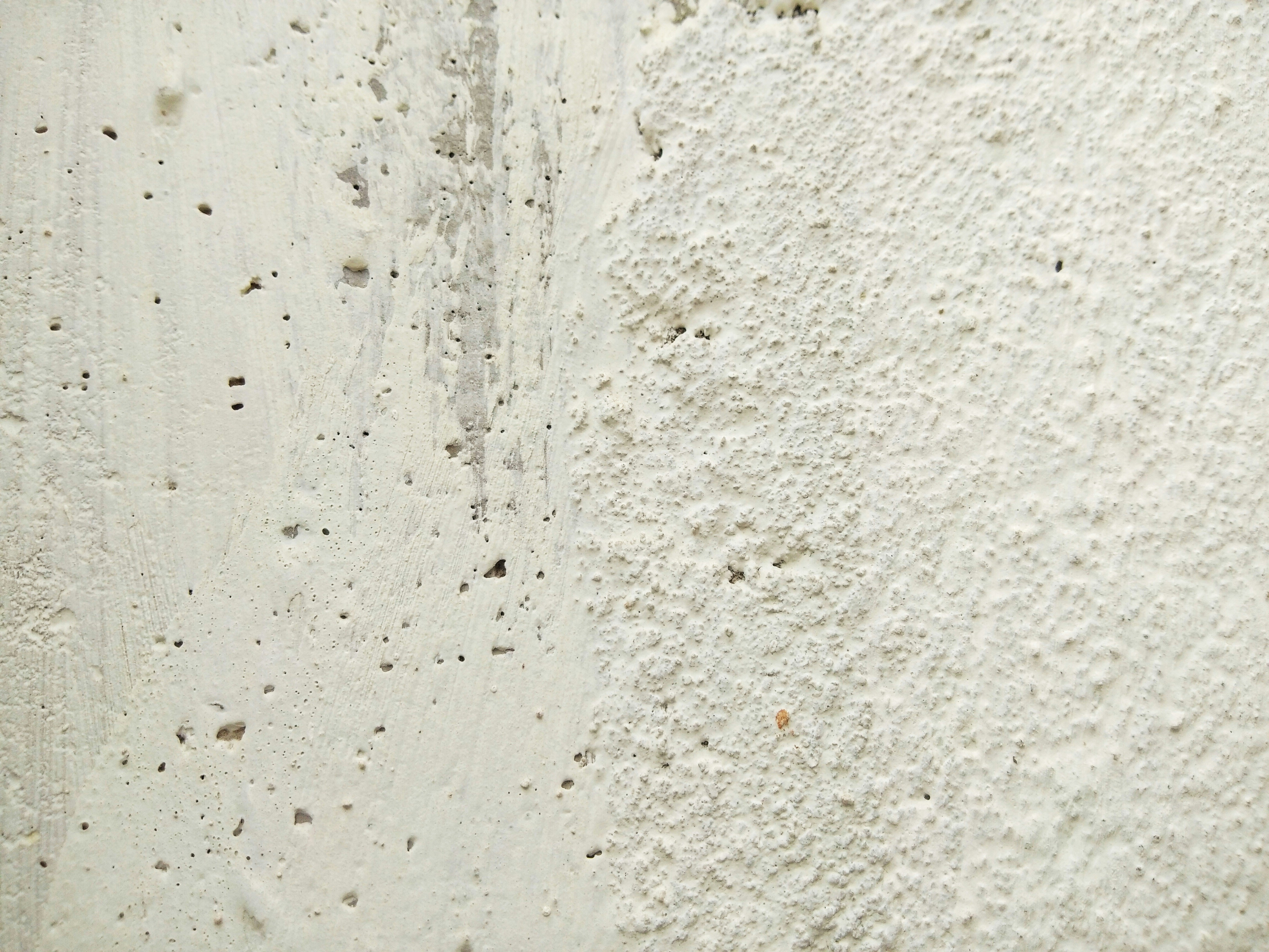Close-up of a textured white wall showcasing varying surfaces and subtle imperfections.