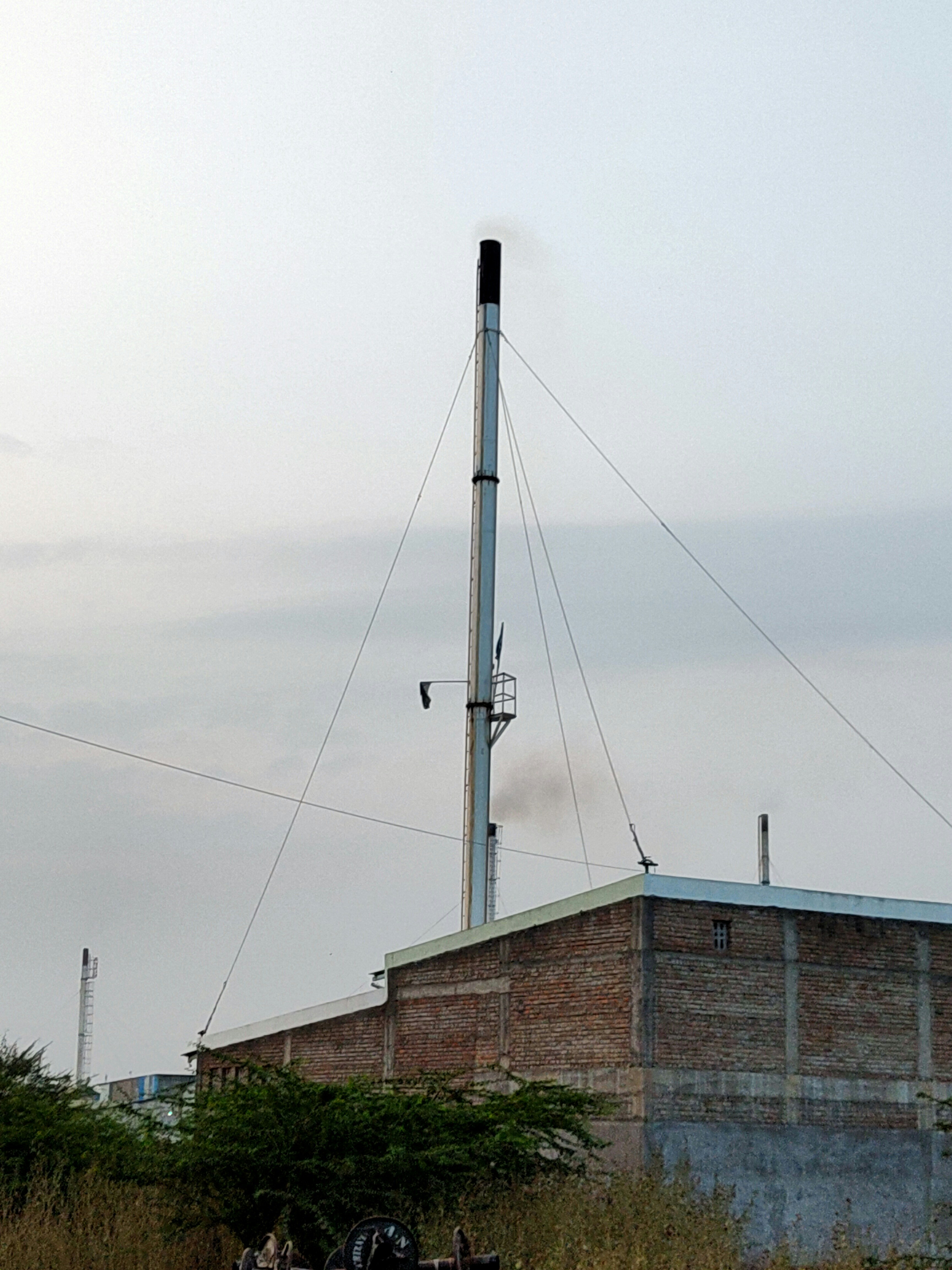 Vertical Sentinel: A Brick Chimney Framed by Taut Cables