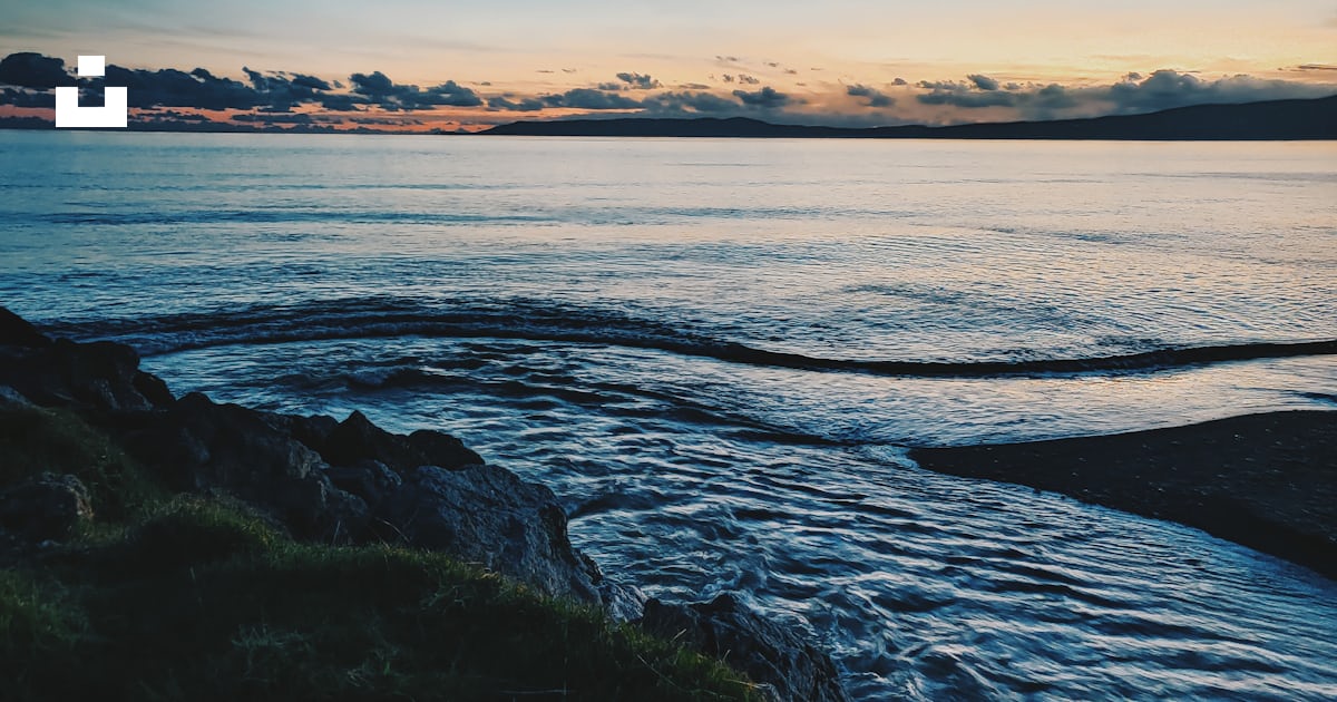 Green Grass Near Body Of Water During Sunset Photo Free Nature Image