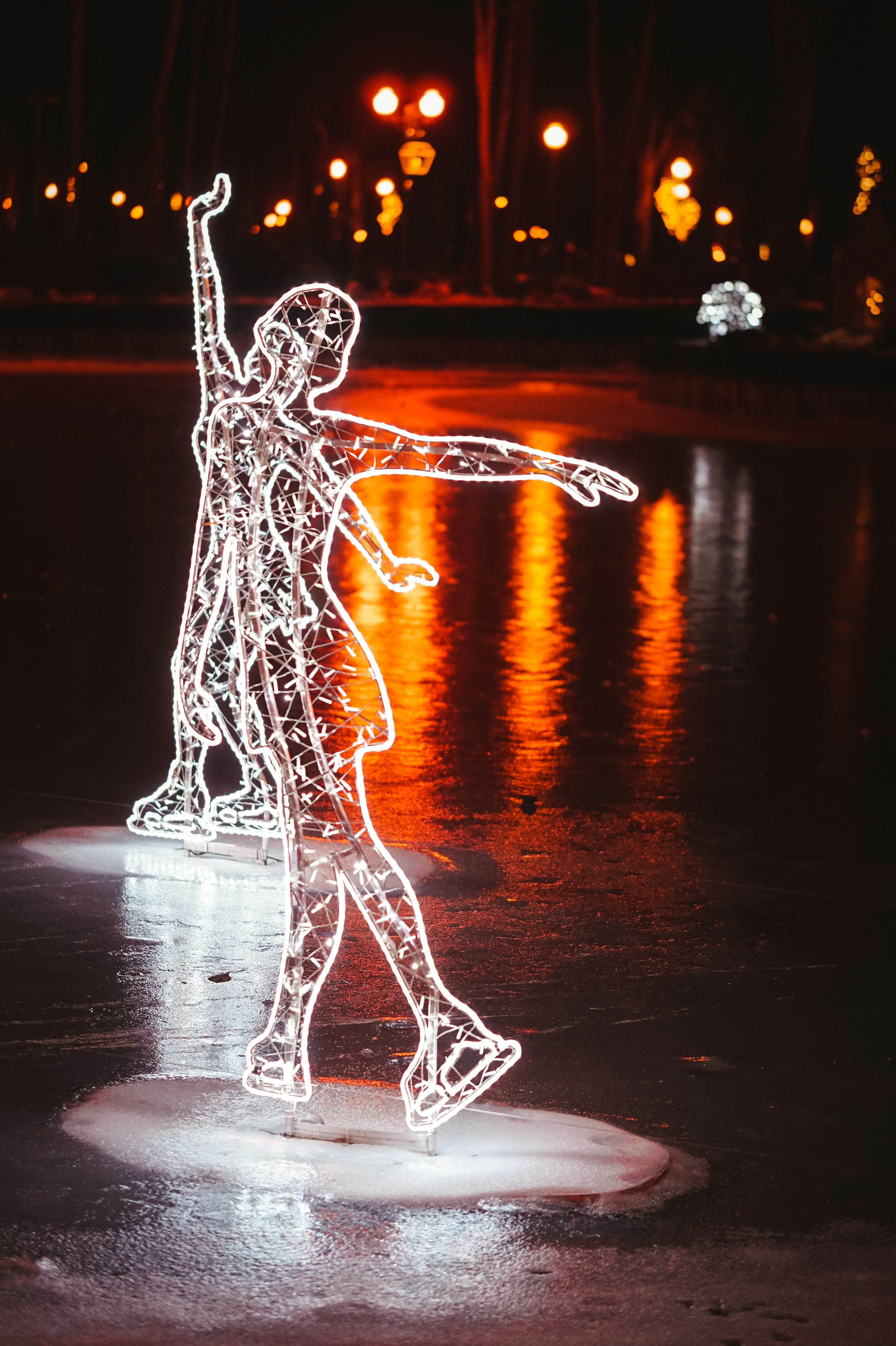 Glowing Figure in Winter Light: A Sculpted Duo in Ice