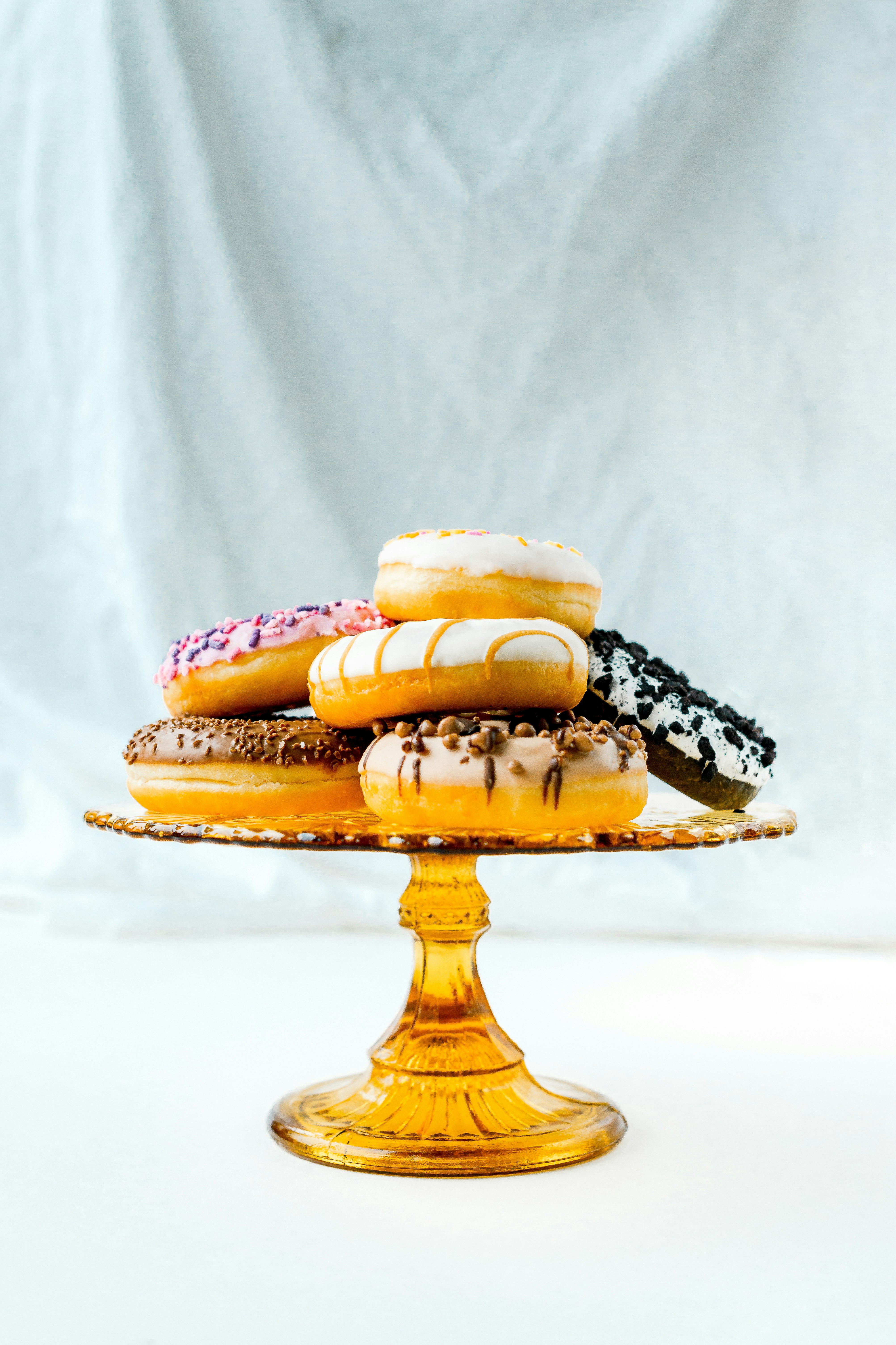 Sugar Summit on Amber Glass: A Donut Tower on a Minimal Stage