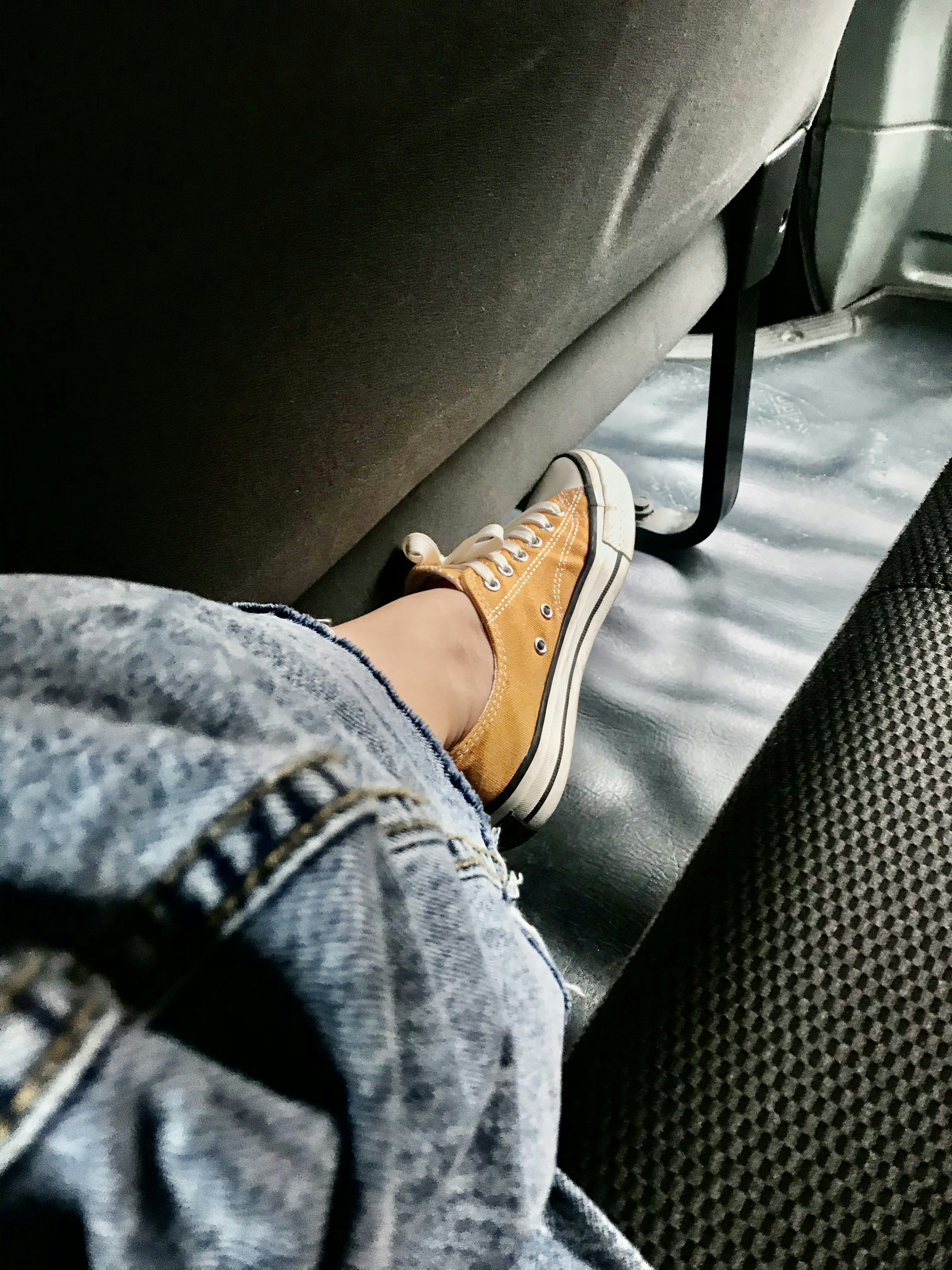 person in blue denim jeans and brown and white nike sneakers