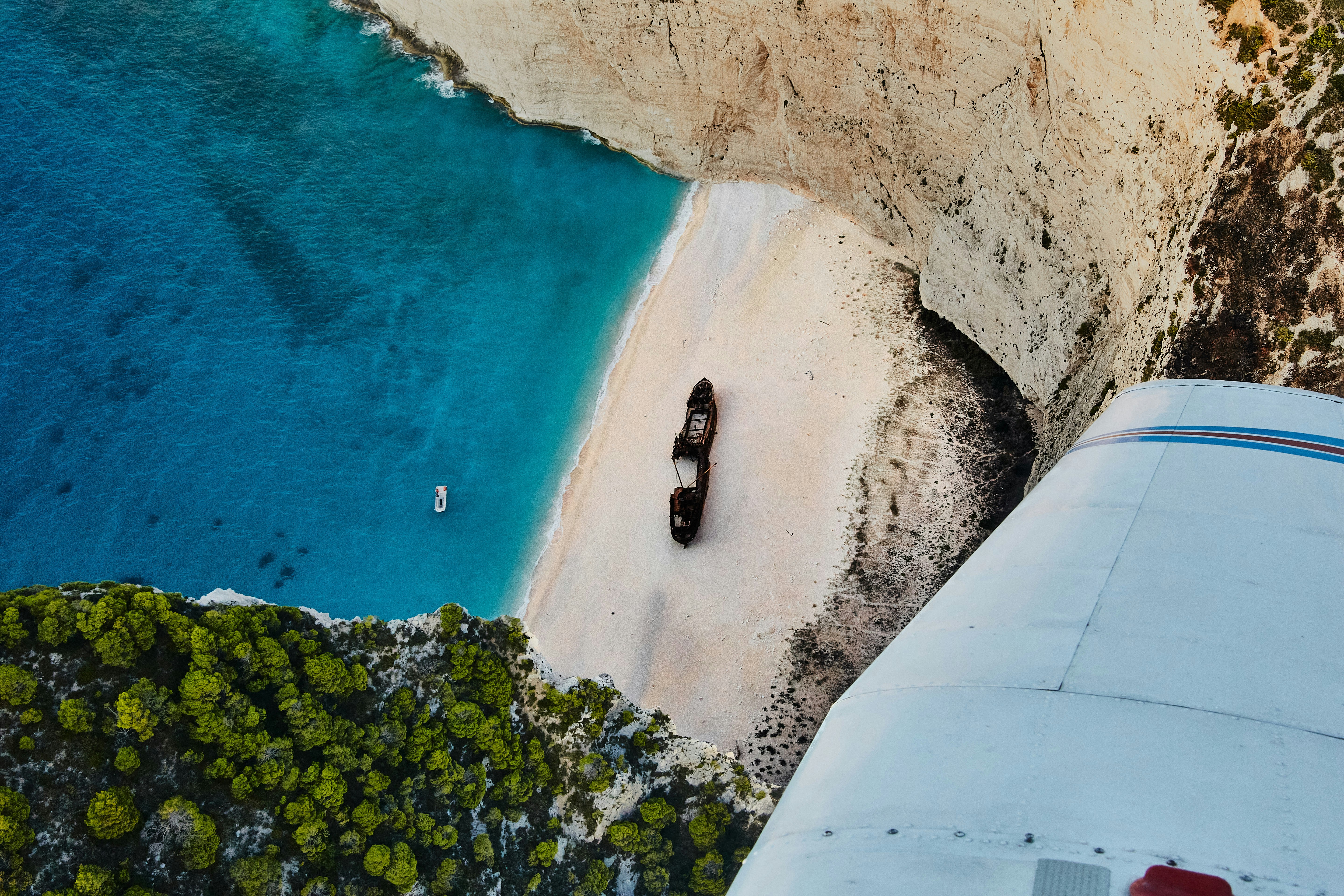 Wingtip Over White Cliff: Aerial Turquoise Cove and Hidden Beach