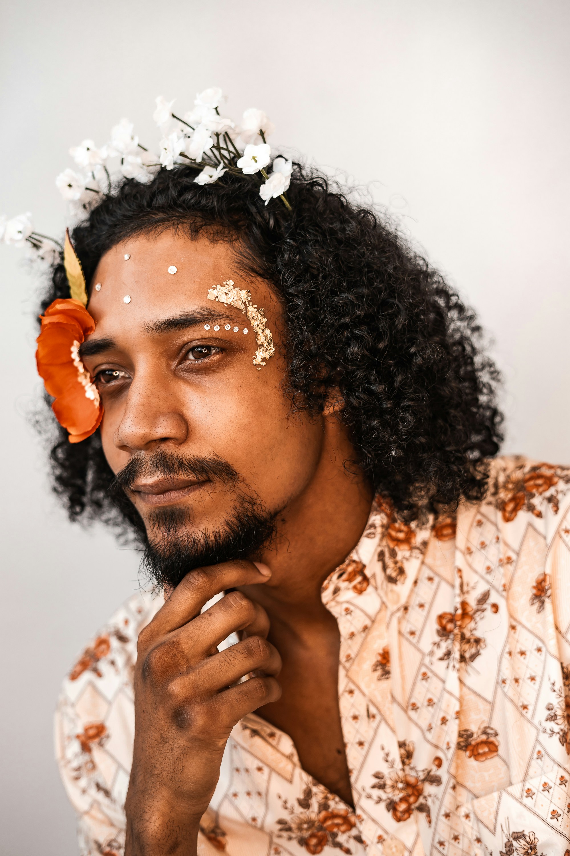 Floral Headdress and Painted Accents: A Contemplative Portrait in Soft Light