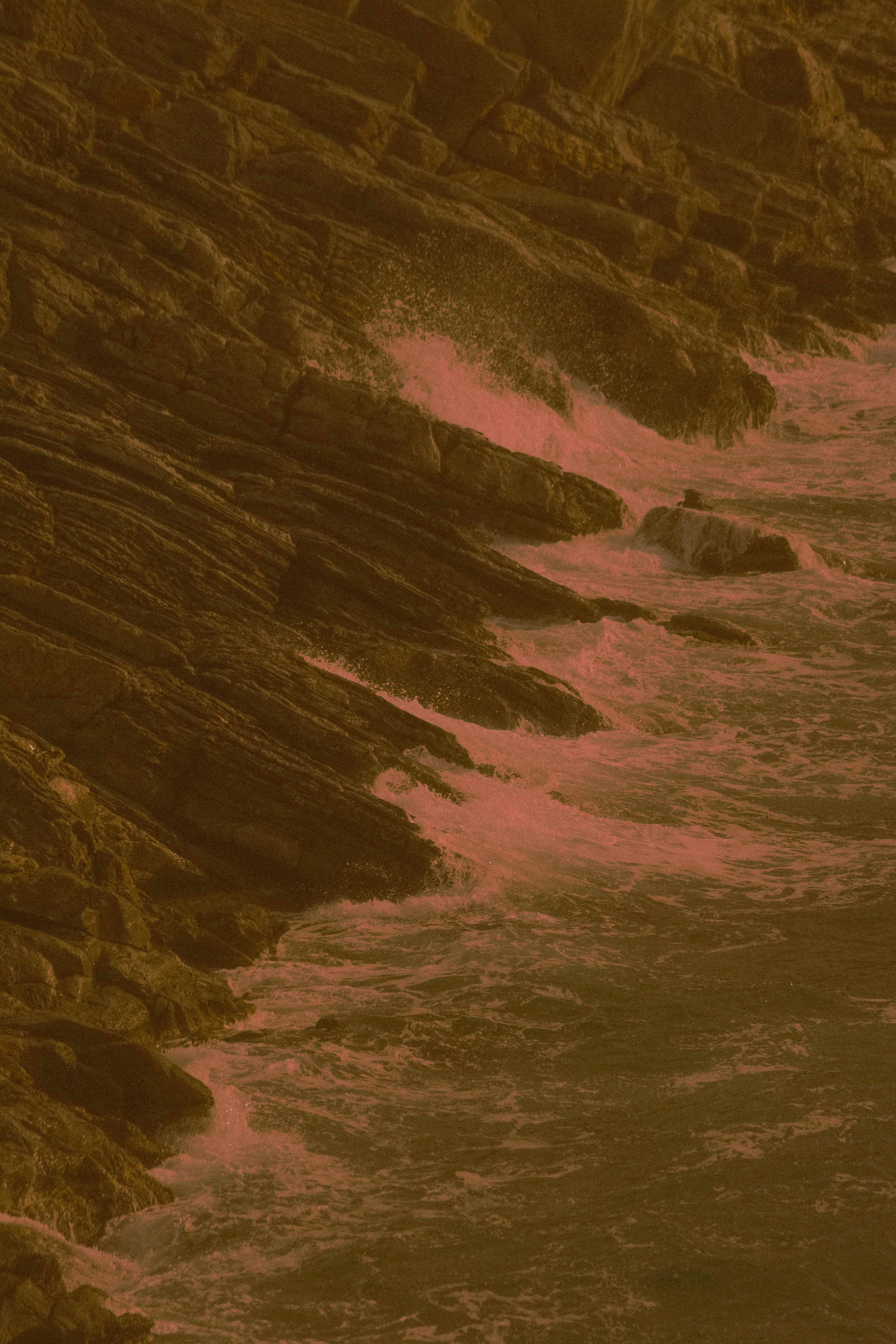 Crimson Coastline: Rugged Rocks and Roaring Waves in Sepia