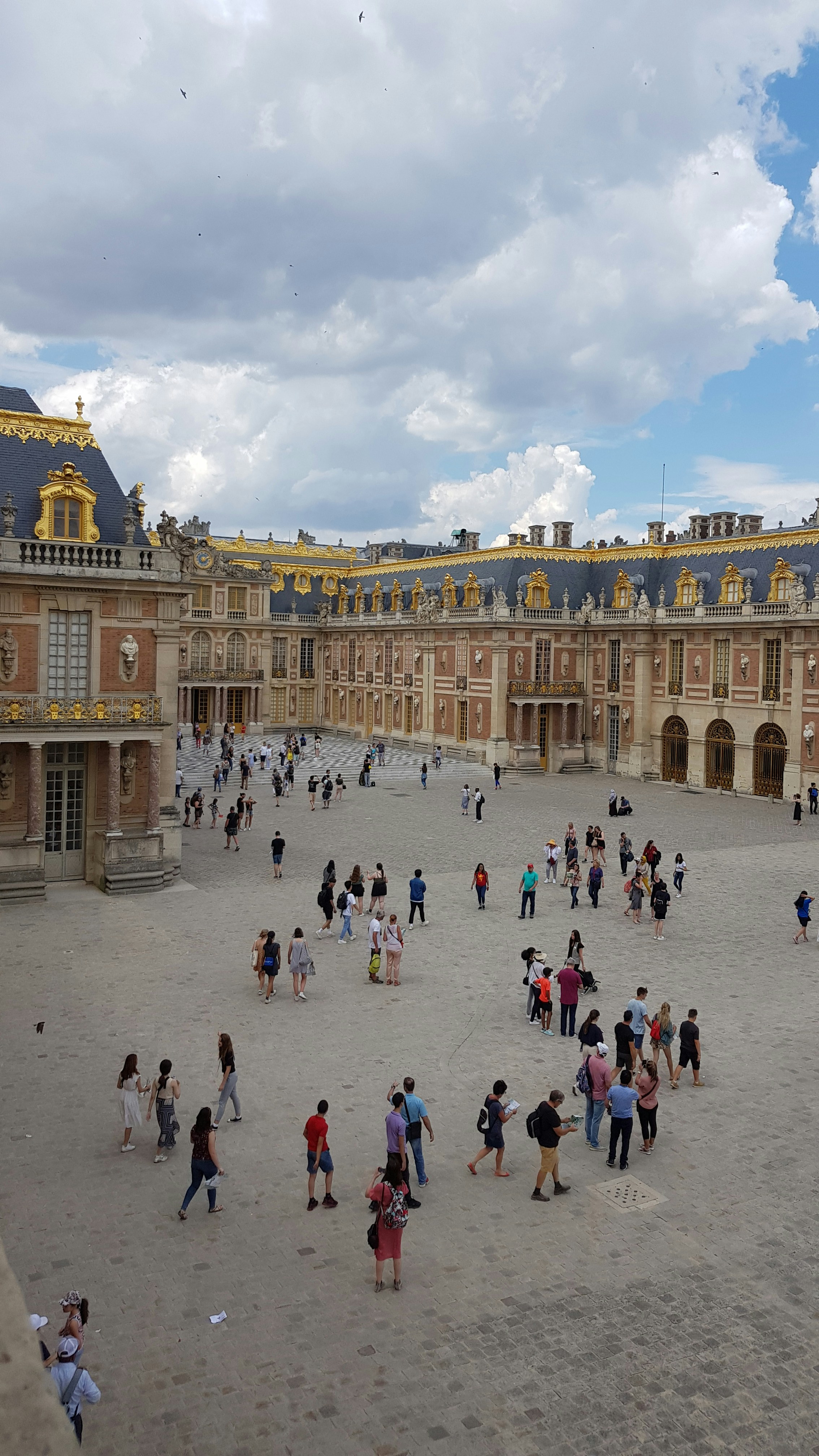 Gold-Trimmed Courtyard: Crowds Move Through a Versailles-inspired Palace Square