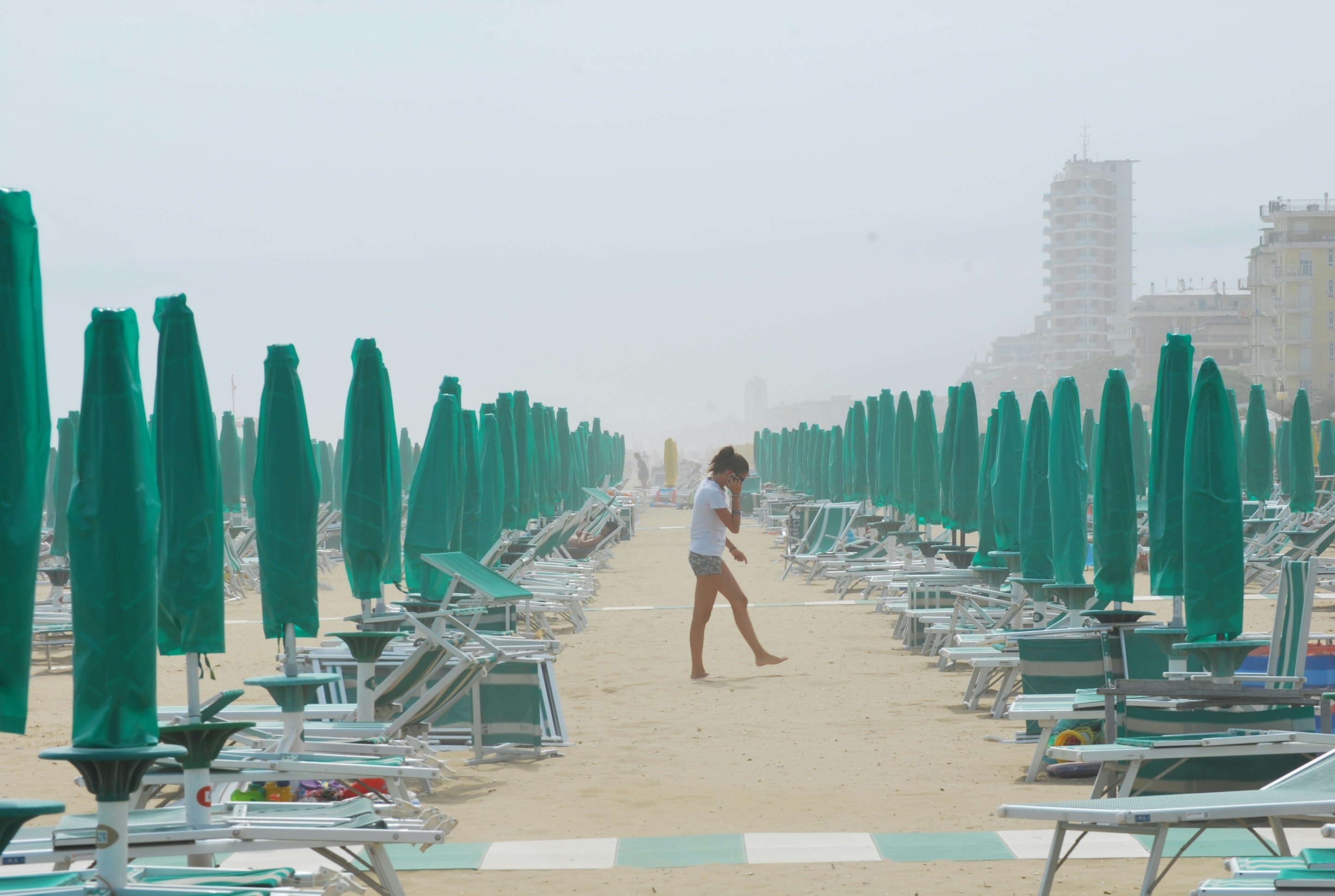 Emerald Aisle on the Beach: A solitary wander beneath rows of sea-green parasols