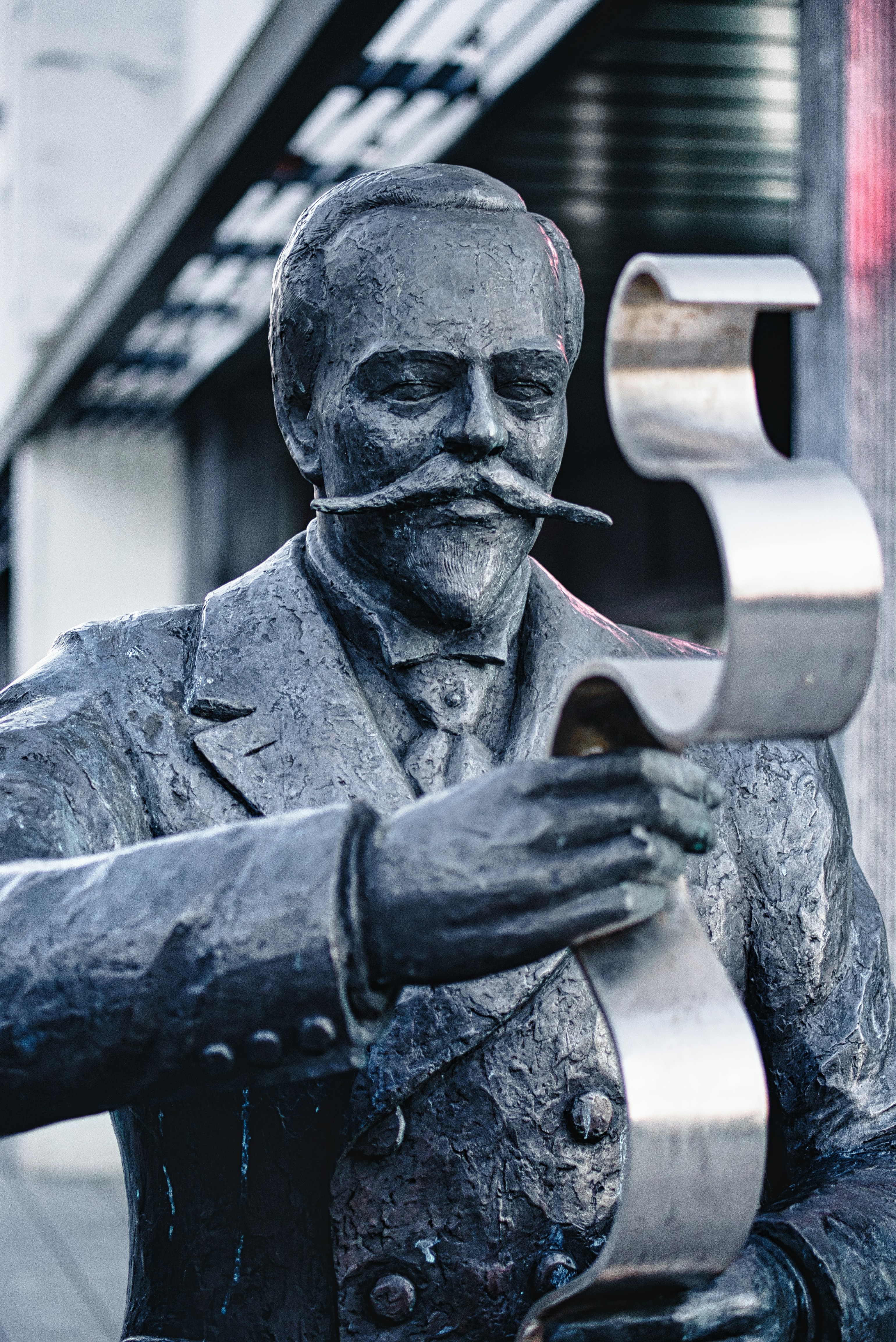 Bronze statue of a distinguished gentleman holding a scroll, showcasing intricate details in his attire and facial expression.