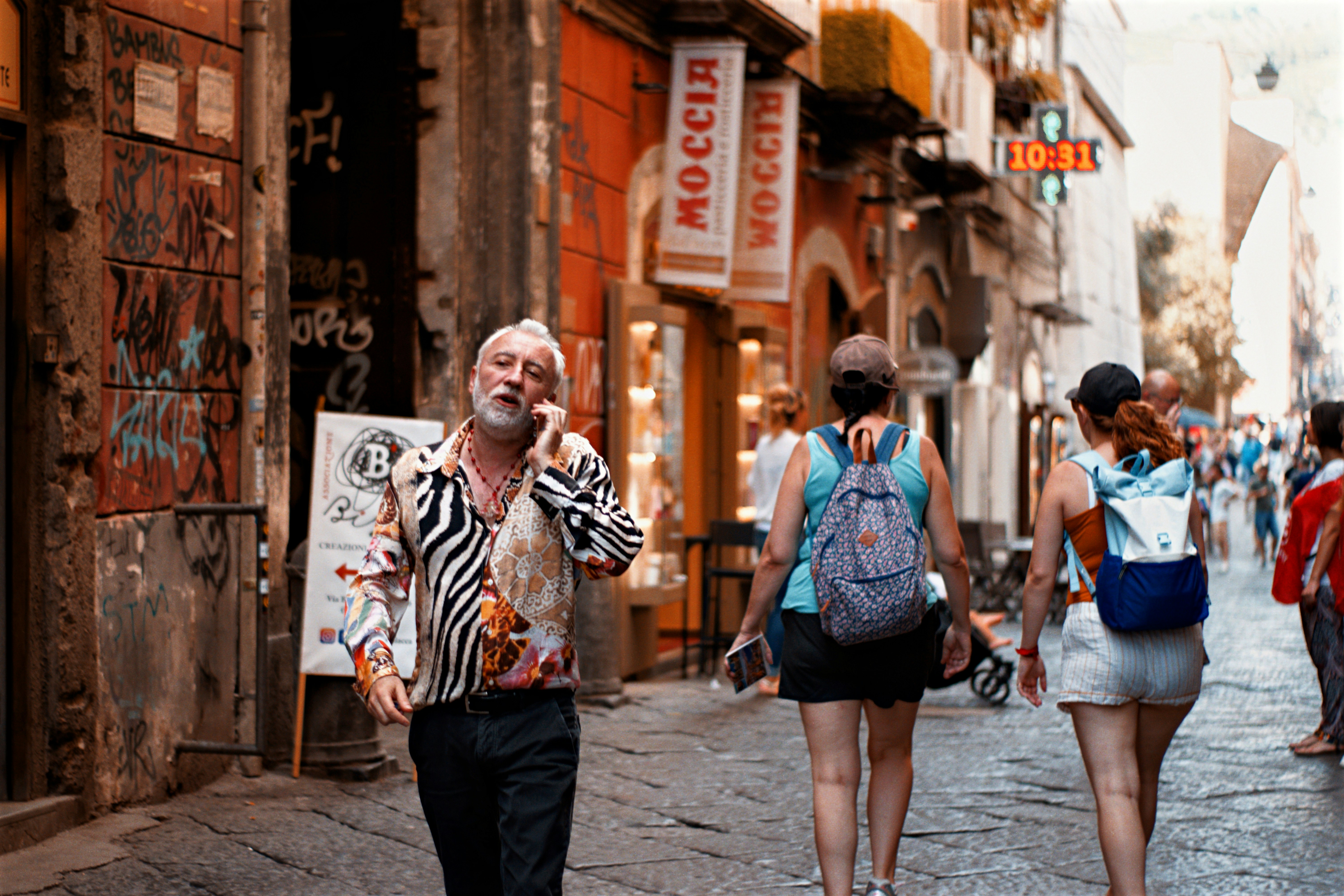 Striped Shirt in the Sunlit Alley: A Street Moment Among Passersby