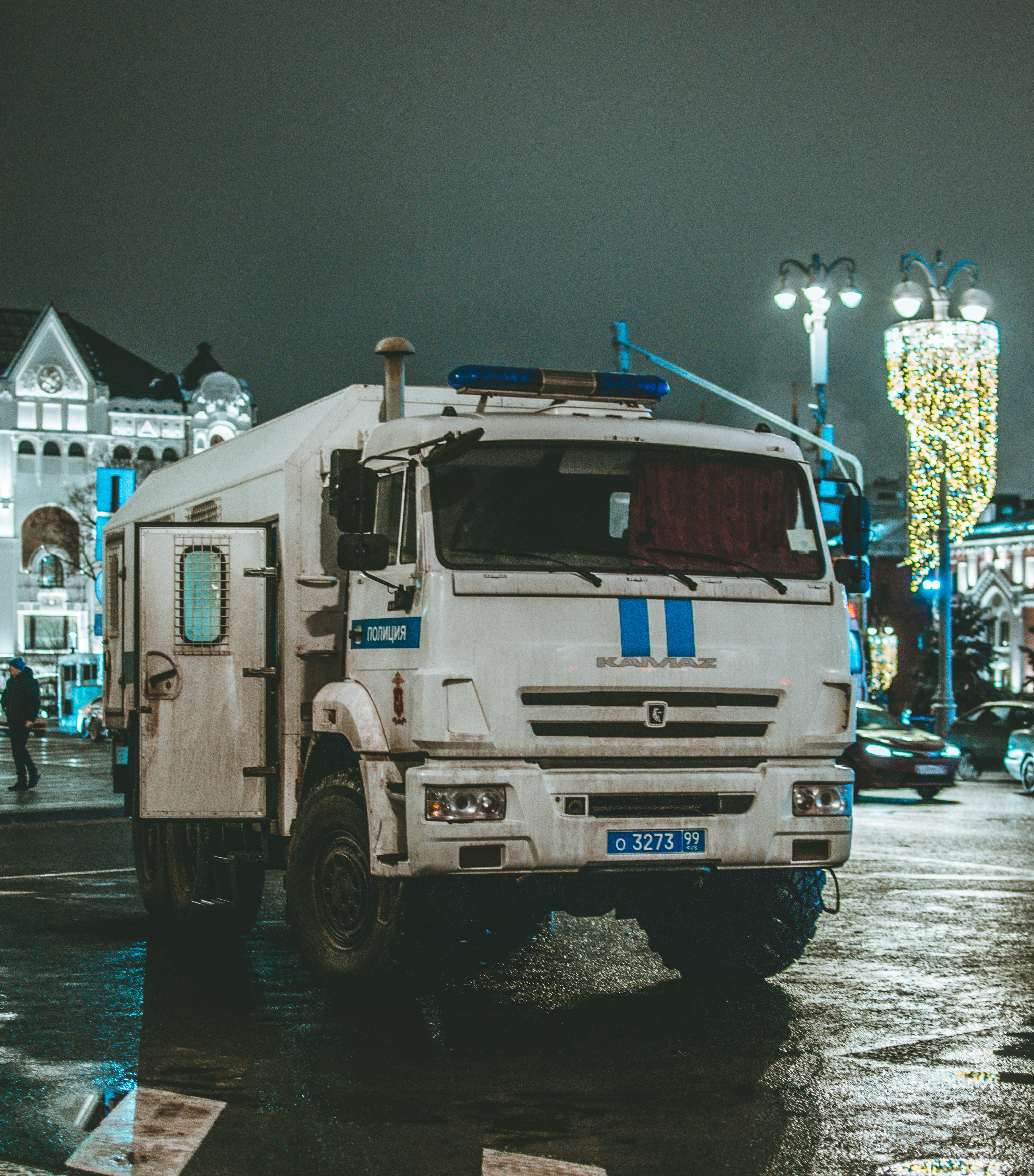 Midnight Sentinel: A White Armored Truck Stands Vigil in a Lantern-Lit City Square