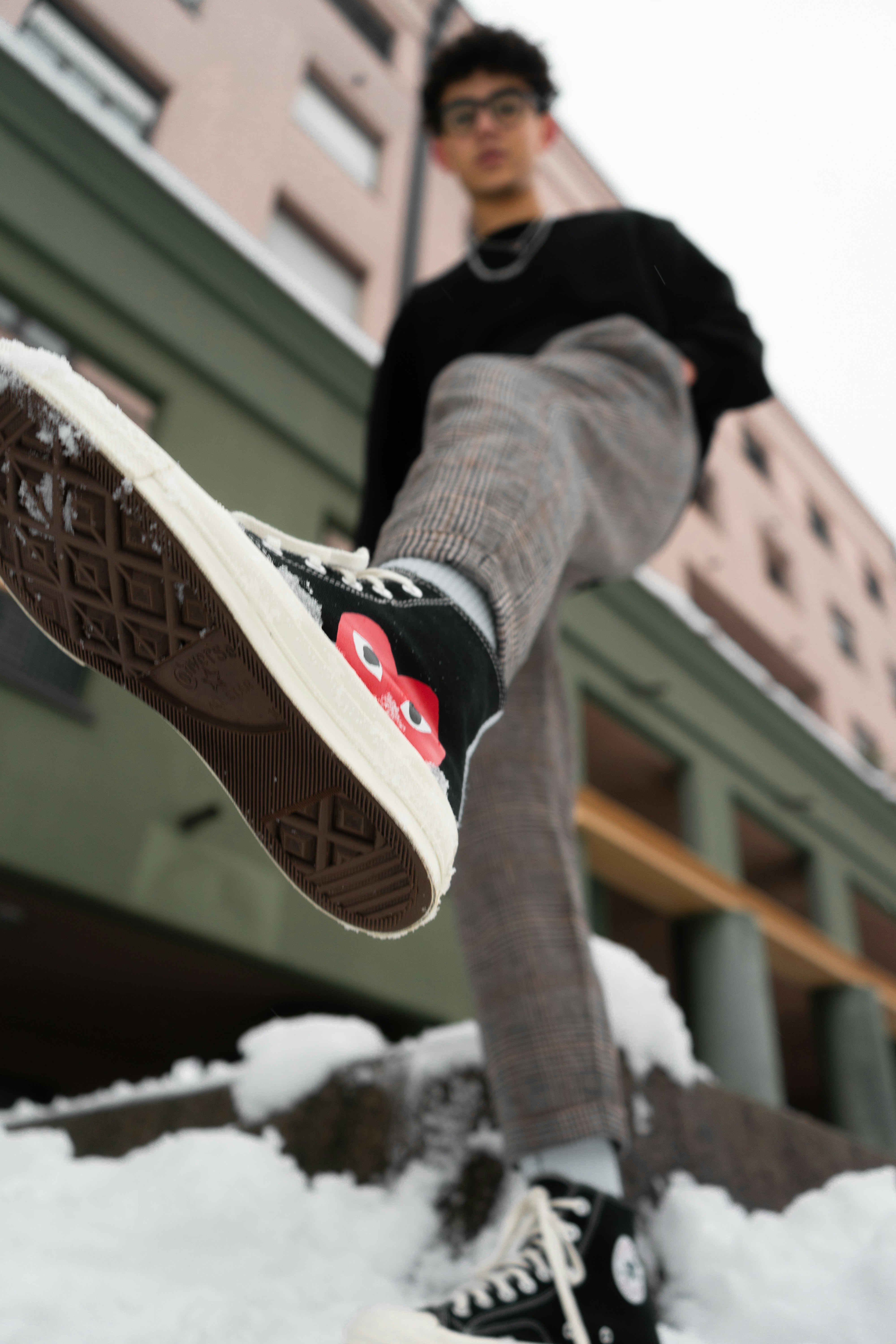 person wearing black and white converse all star high top sneakers