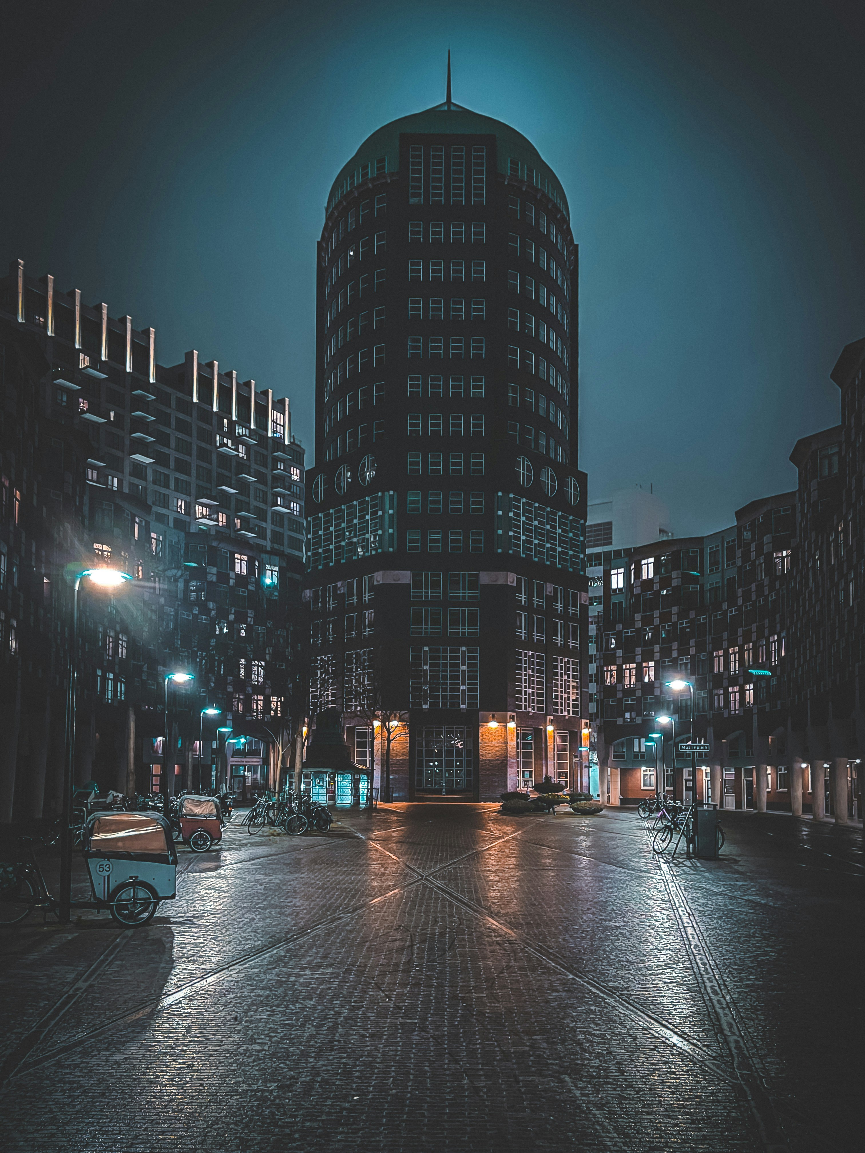 People walking on sidewalk near high rise buildings during night time ...