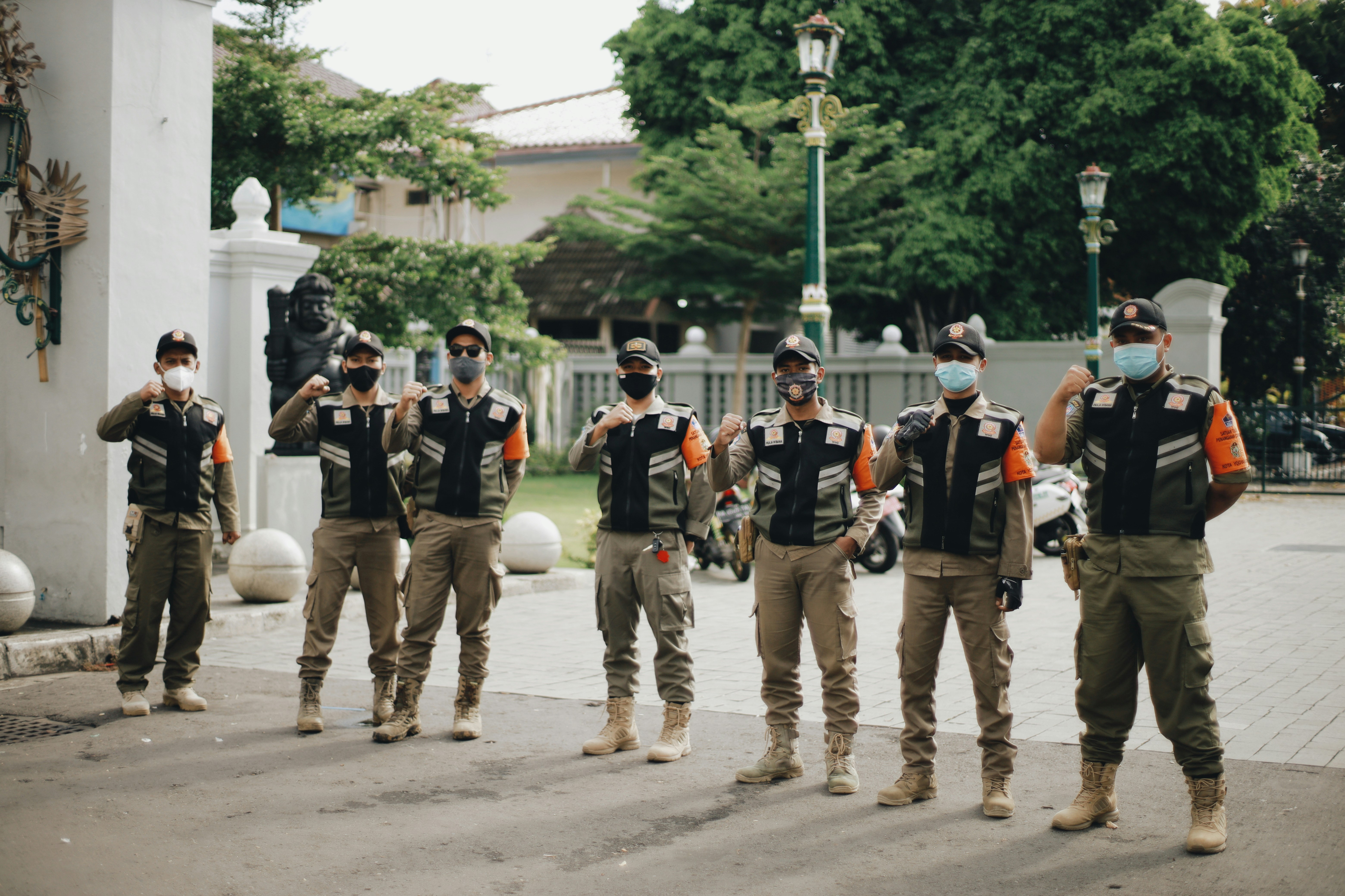 Uniformed silhouettes salute in a sunlit courtyard