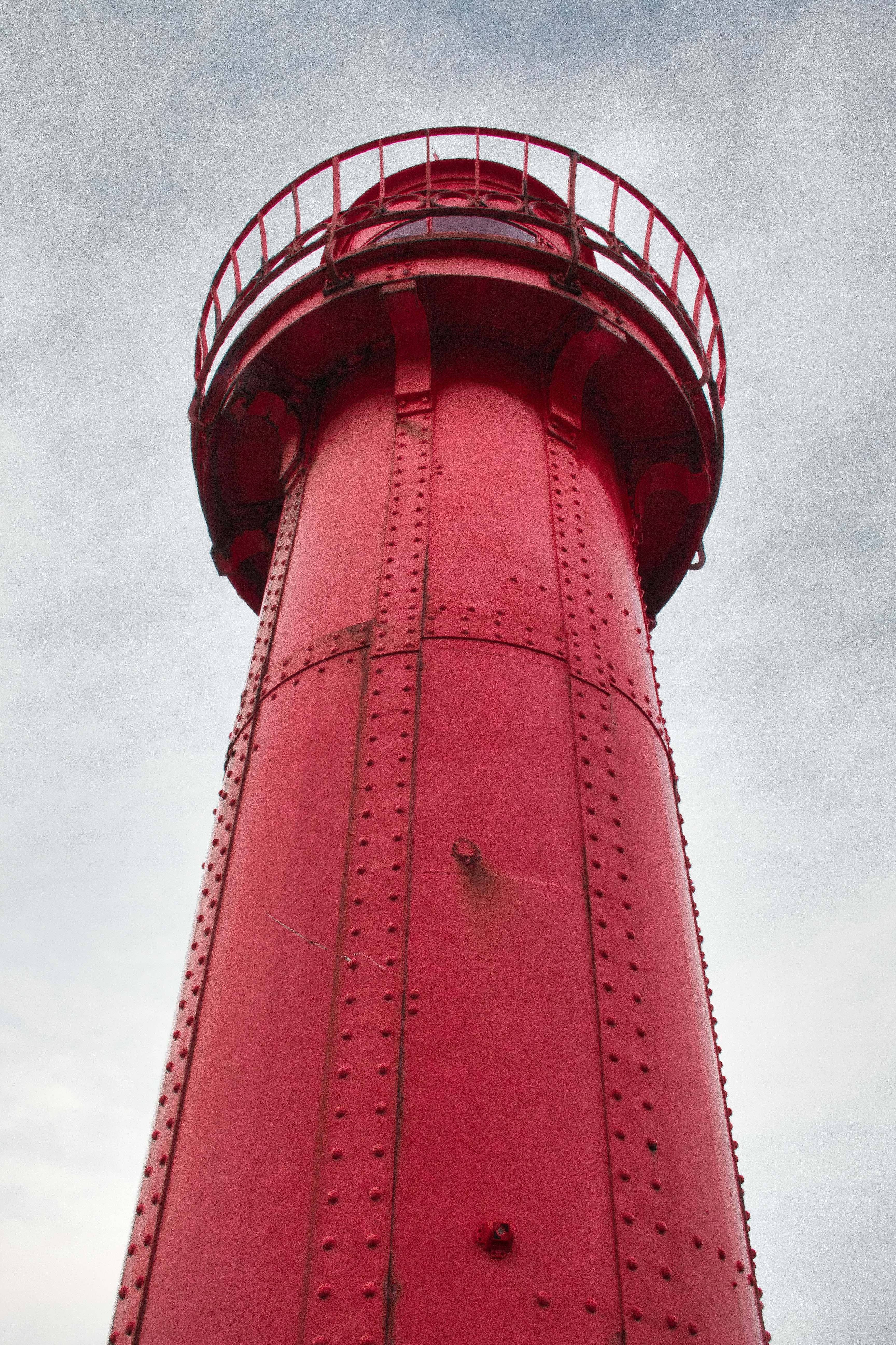 Crimson Sentinel: A Low-Angle Portrait of a Red Lighthouse