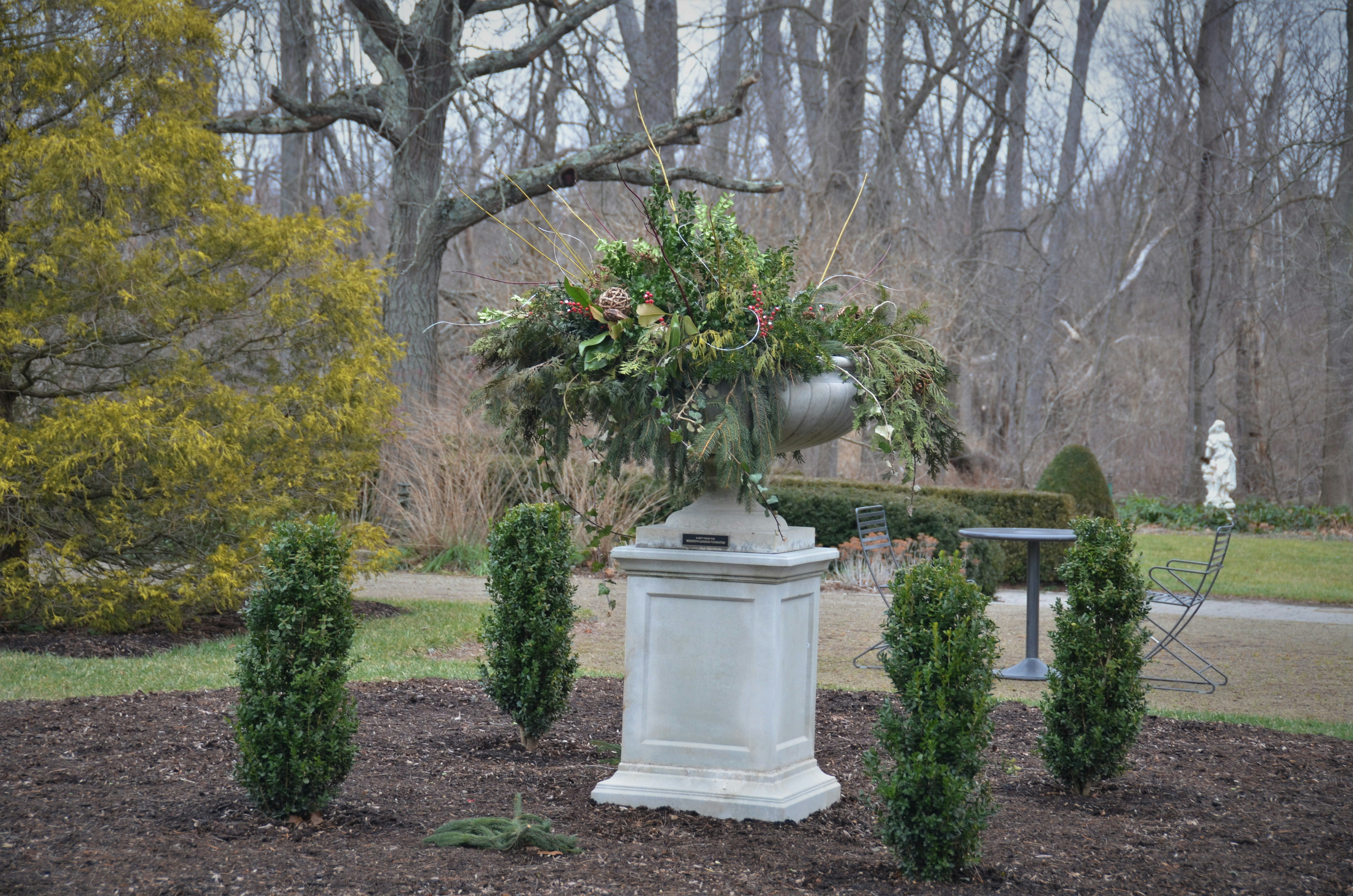 Floral Crown on a Classical Pedestal in a Quiet Garden