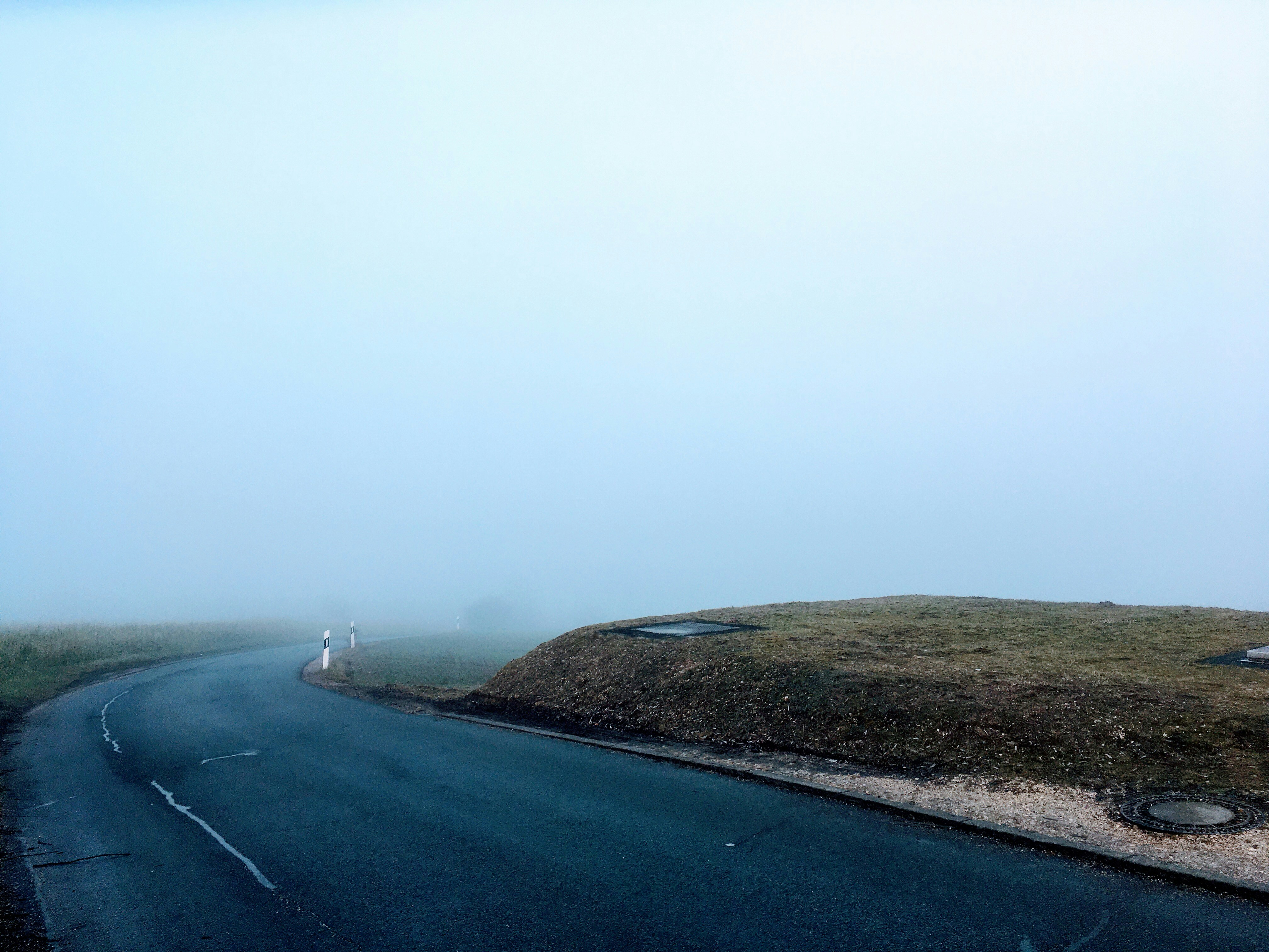 Mist-Wrapped Curve: A Road Fading into Quiet Highlands