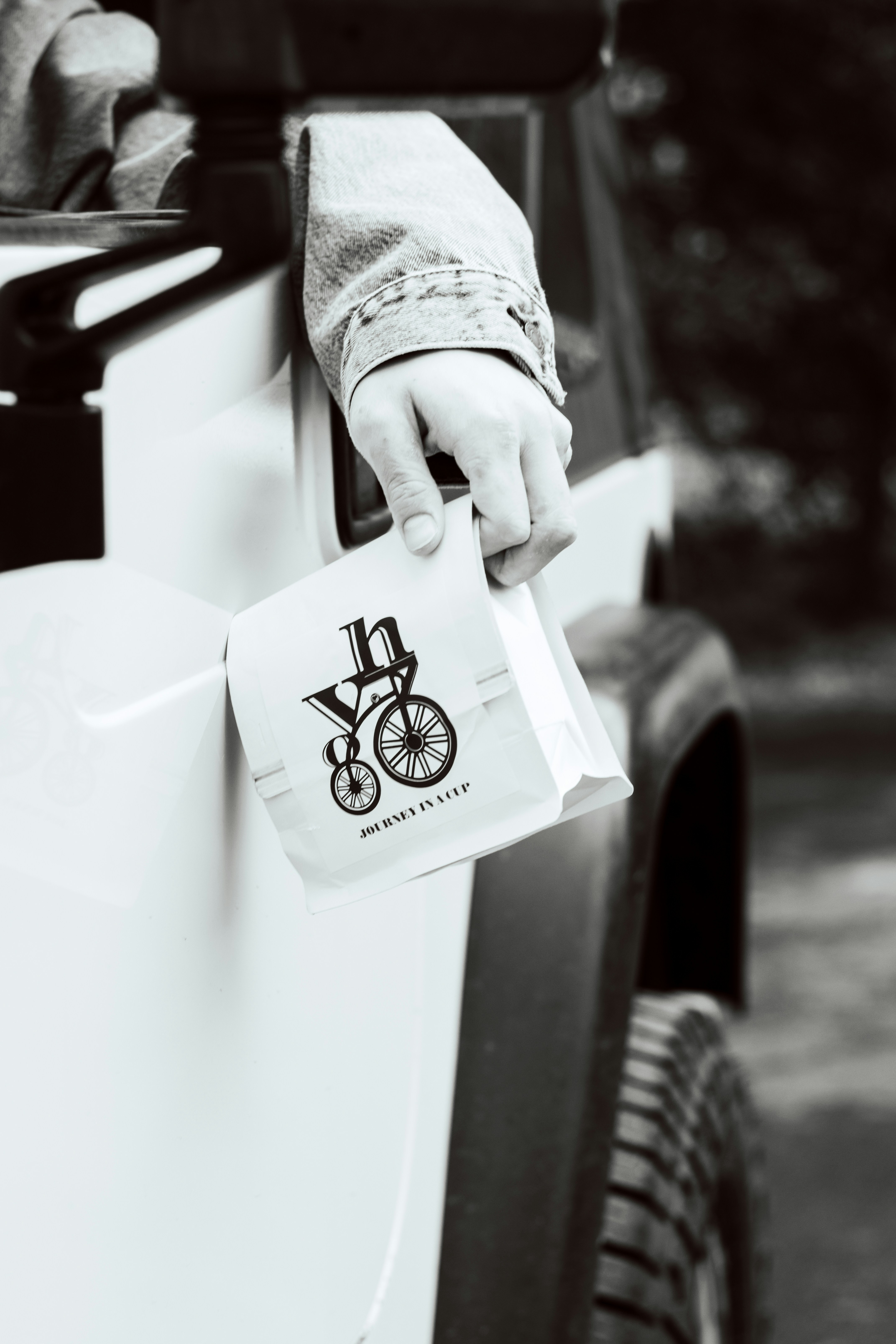 Handing off a bag of wheels: a quiet moment by the vintage vehicle