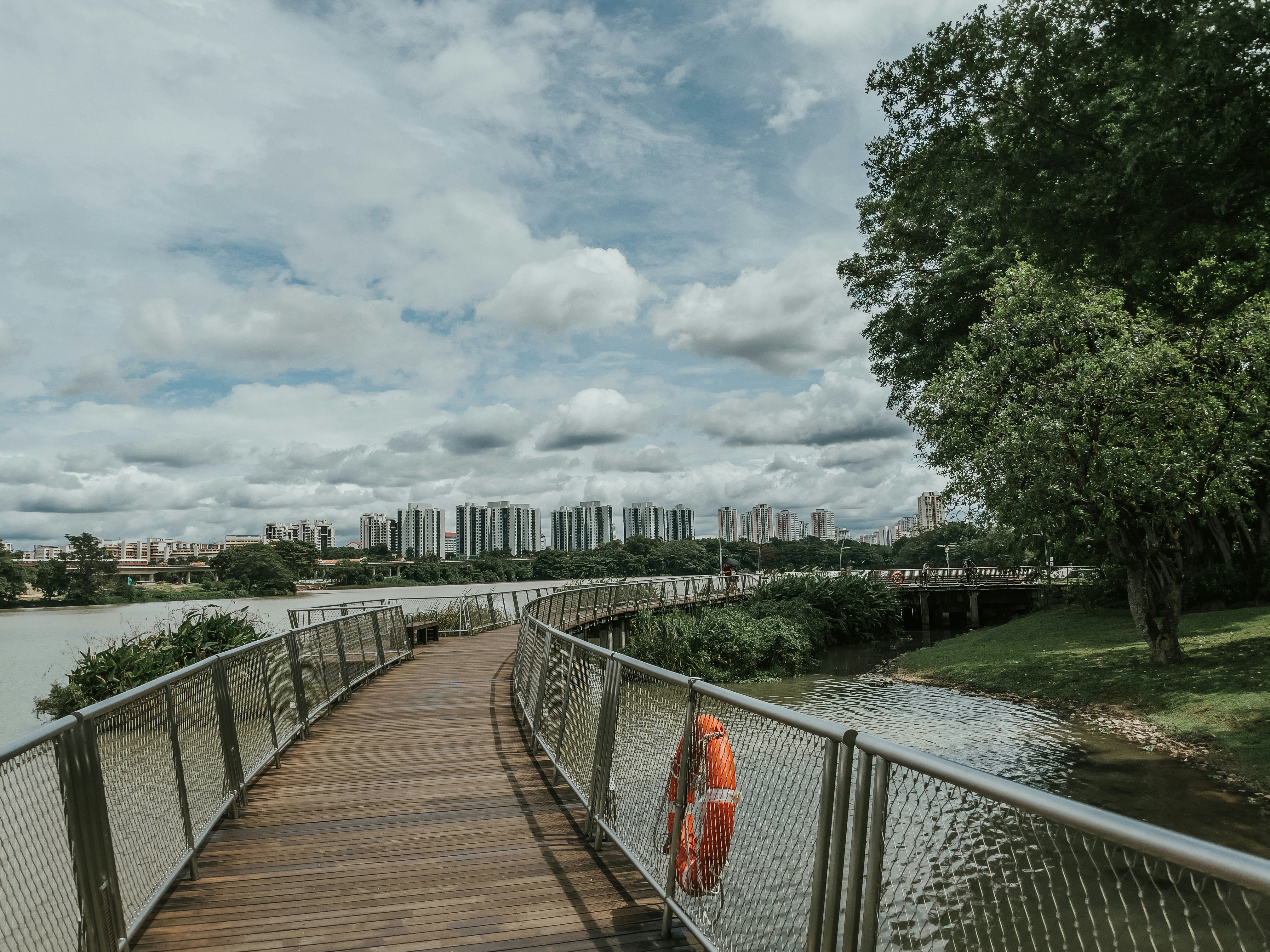 Bridge Walkway Over Calm Lake with City Skyline