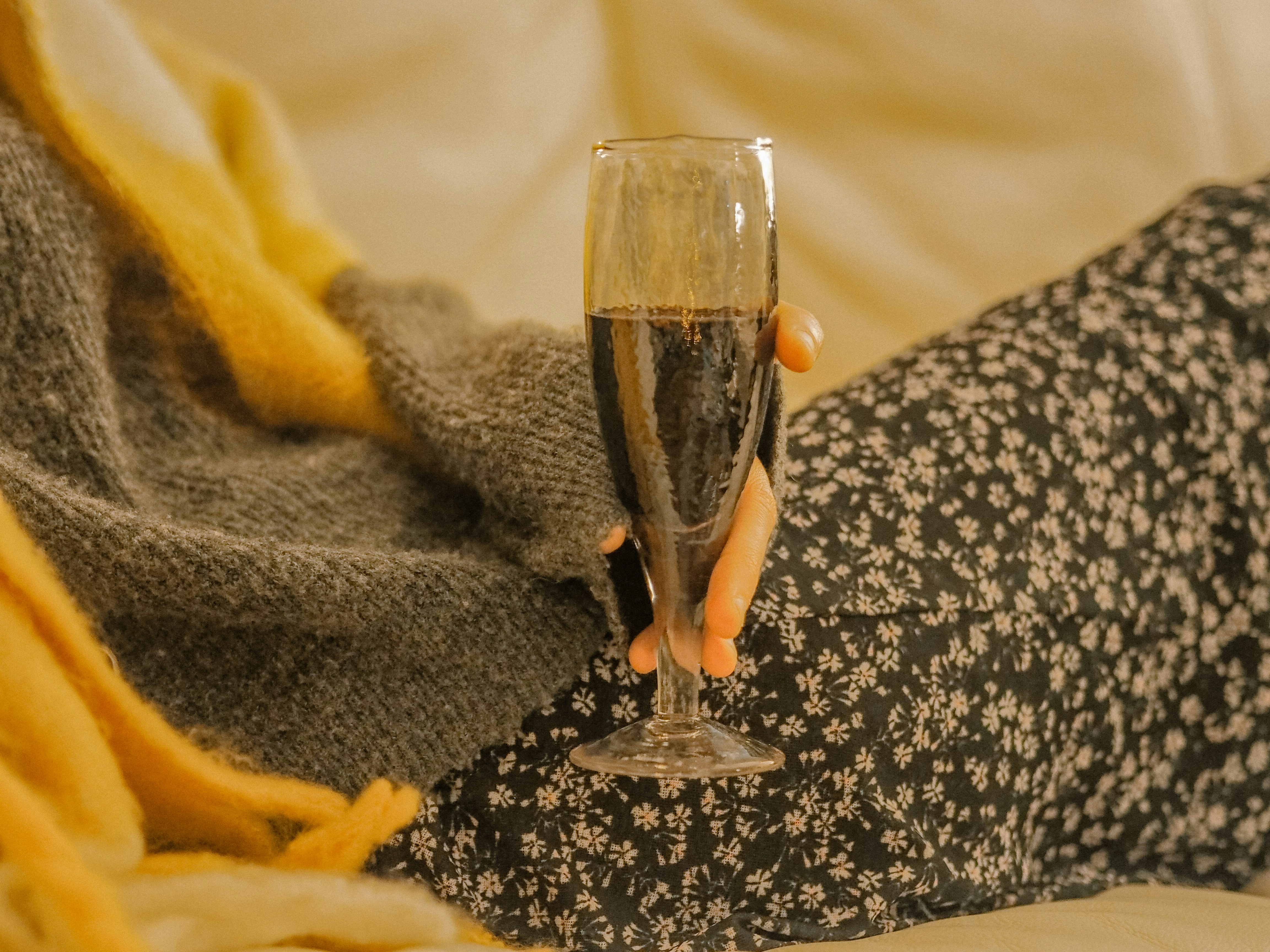 Cozy Glow: a Champagne Flute Cradled by Knits and Florals