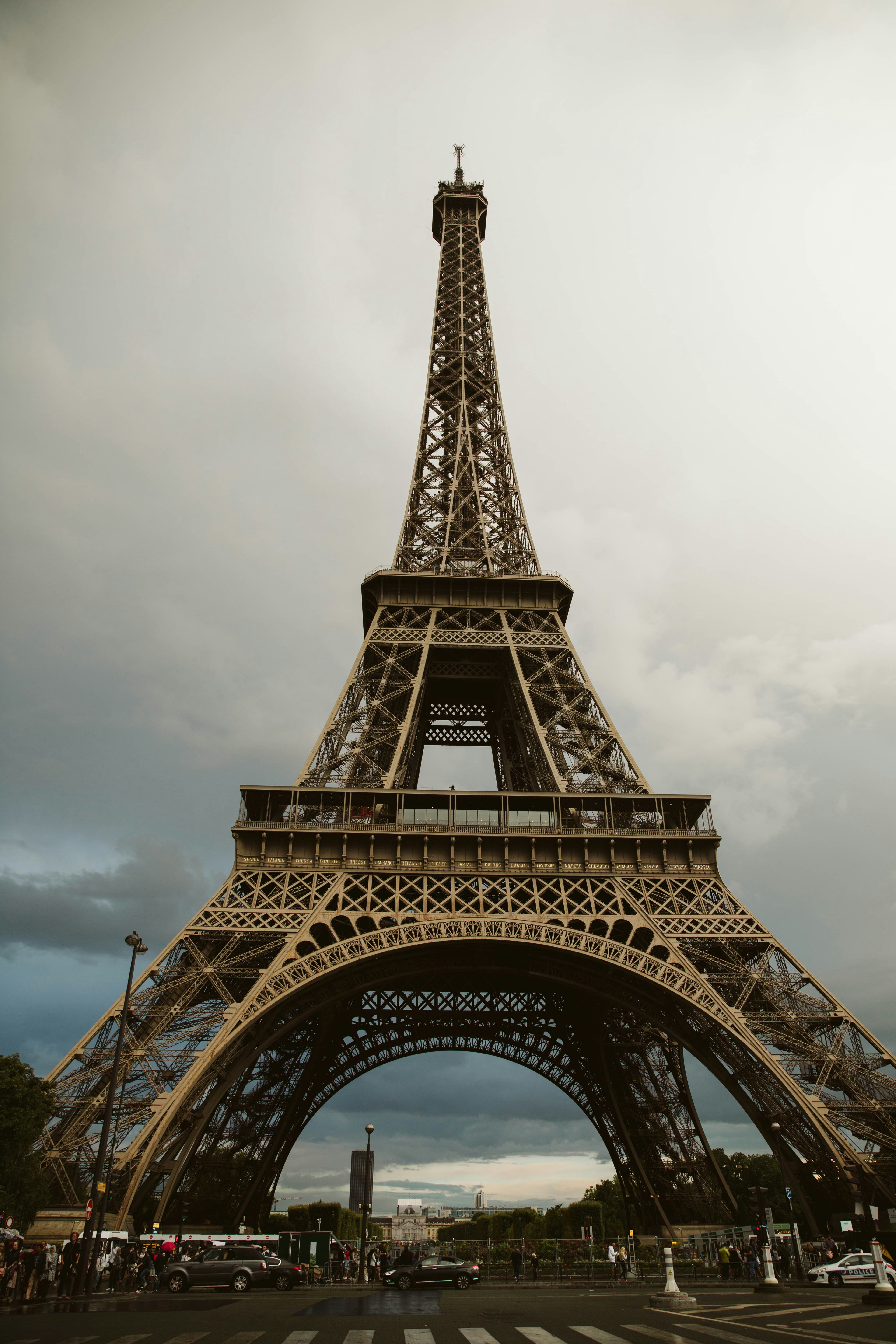 The Eiffel Tower rises majestically against a moody sky, showcasing its intricate iron lattice work and architectural grandeur.