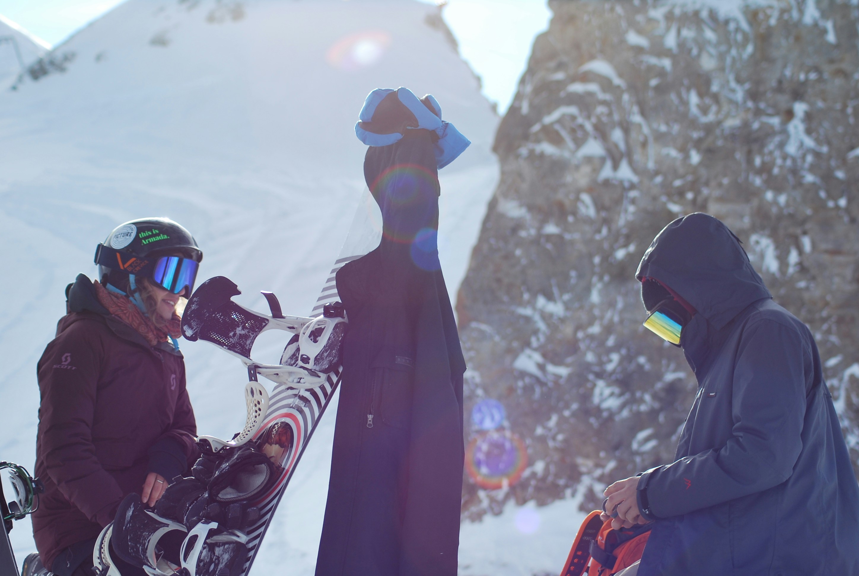 Snowboarder’s Prep with Snowy Peaks in the Backdrop