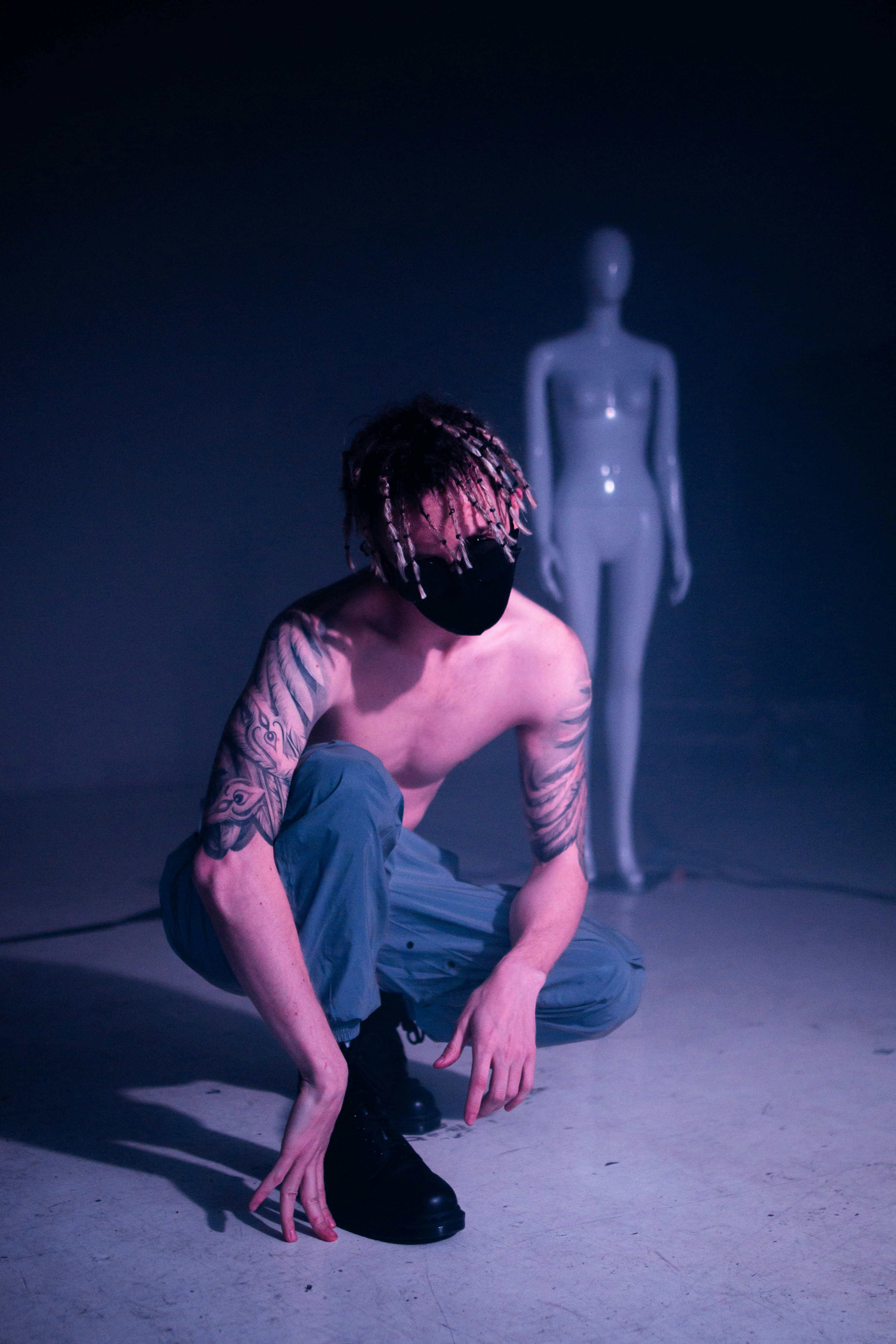Shadowed Vigil: A Tattooed Figure in Neon Stillness