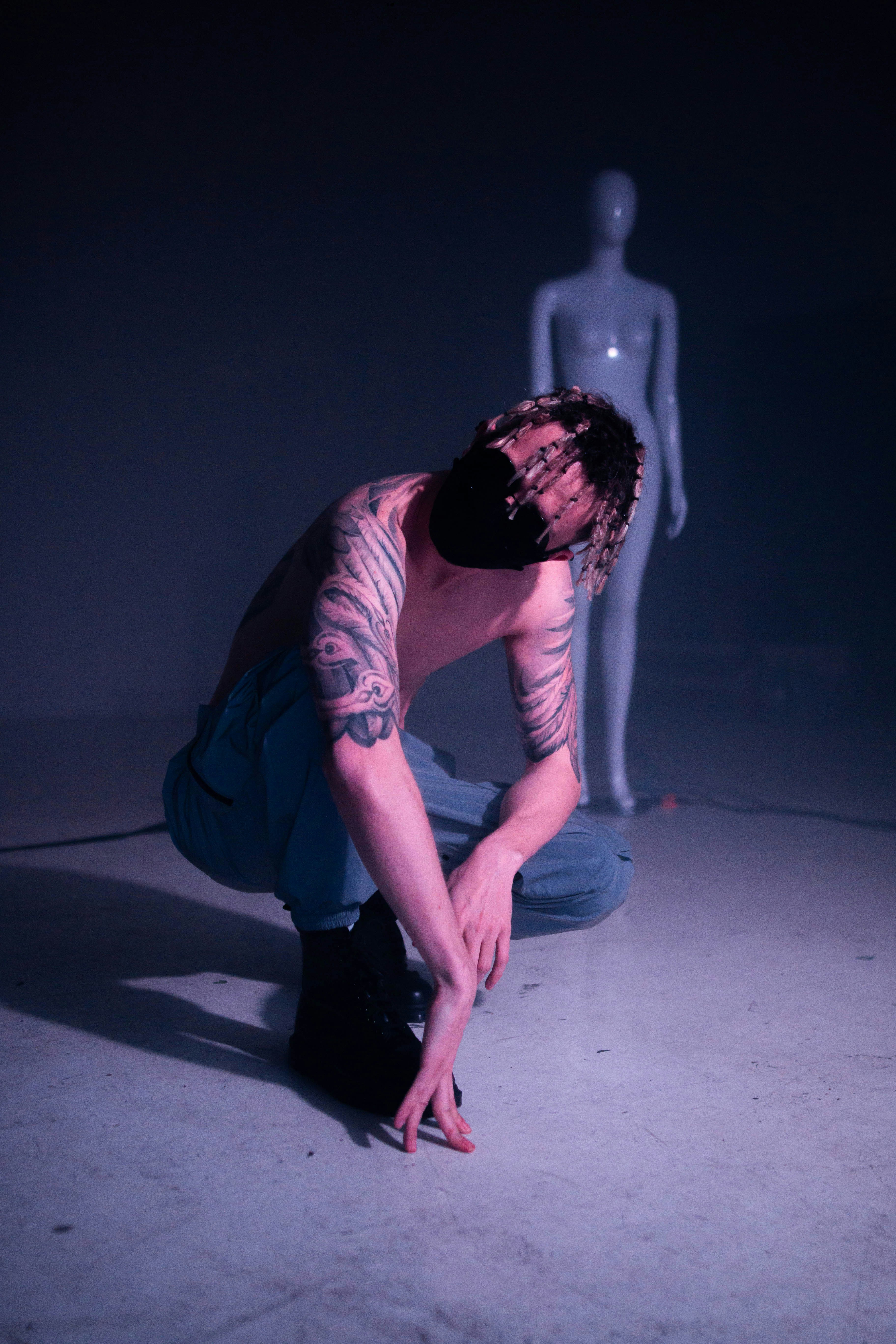 Dancer in Shadow: A Tilted Pose Beneath a Silent Figure