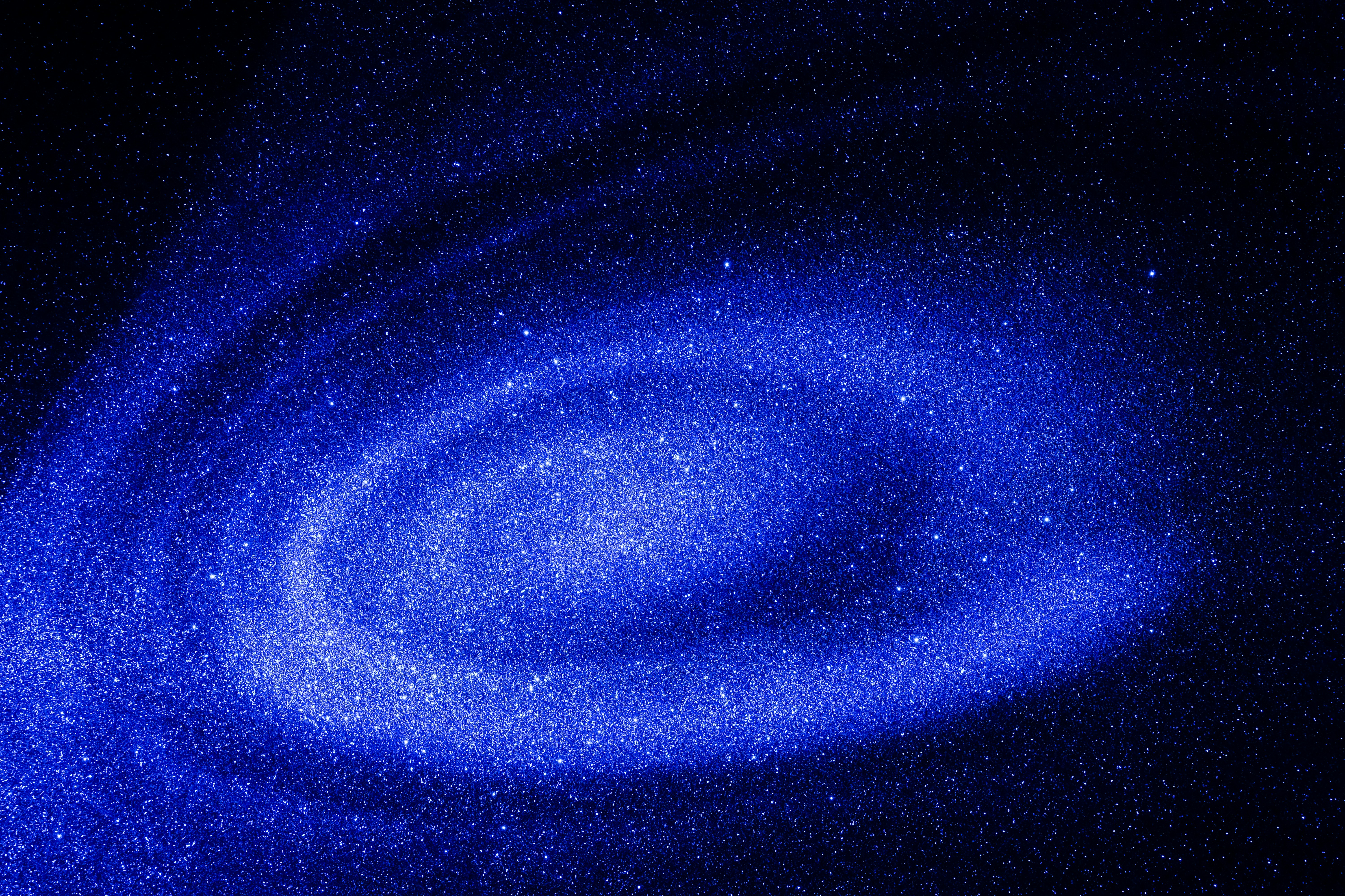 Abstract depiction of a galaxy with swirling blue particles against a dark backdrop.