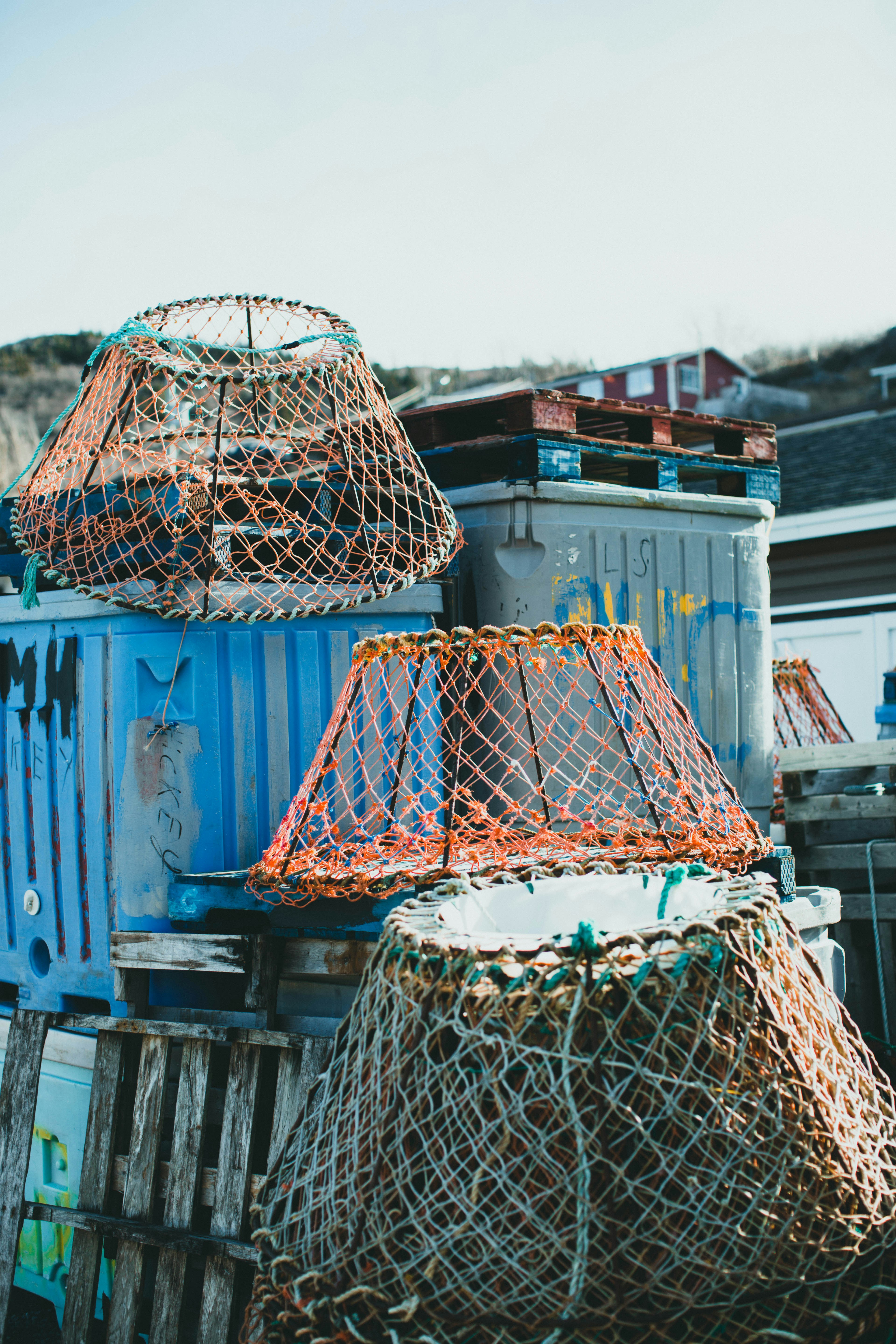 Colorful lobster traps stacked against a backdrop of rustic crates and buildings, highlighting the essence of coastal fishing culture.