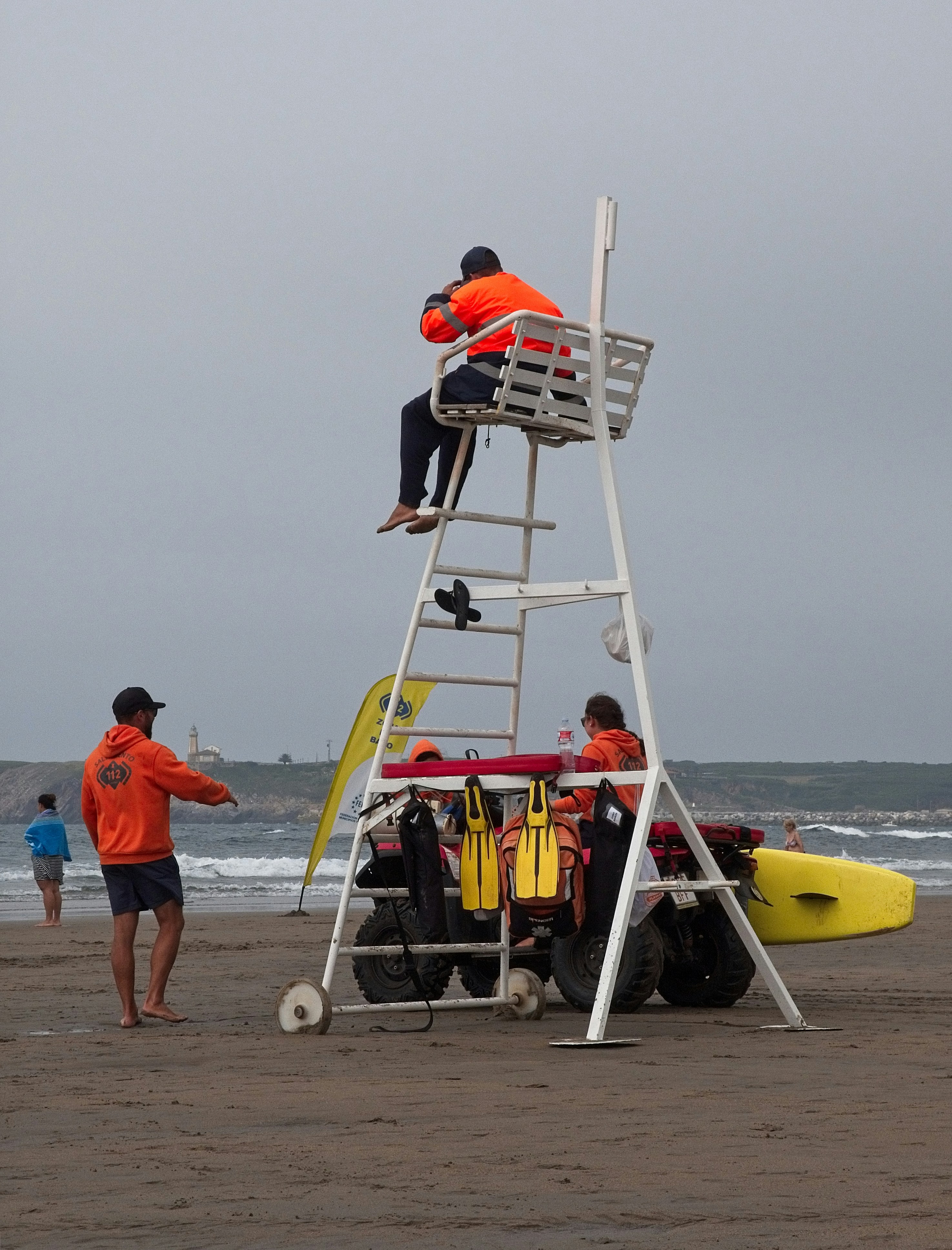 Orange Sentinel on a White Lifeguard Tower Over a Windy Beach