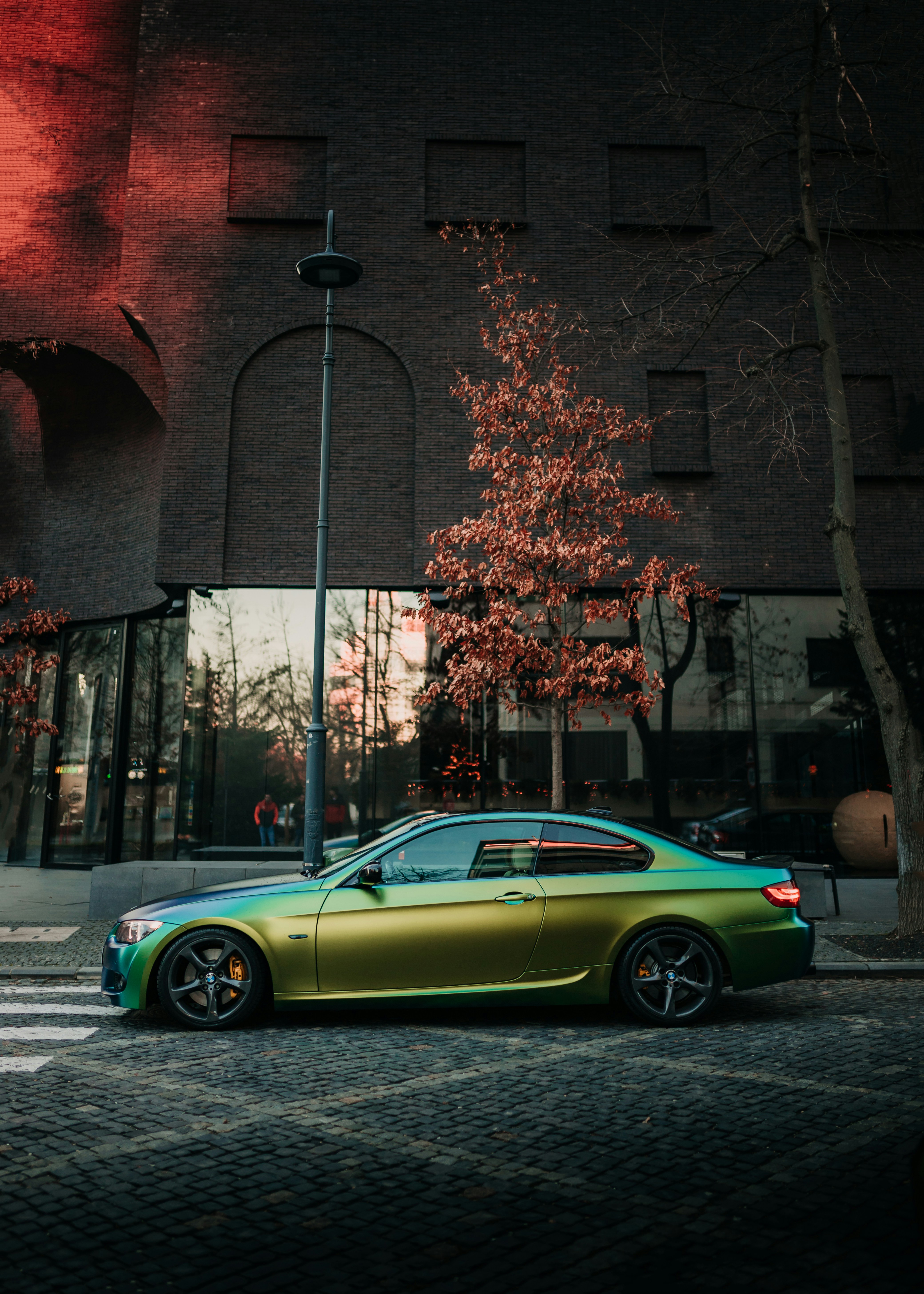 Chromatic Drift: Emerald Green Aston Martin on a Cobblestone Street