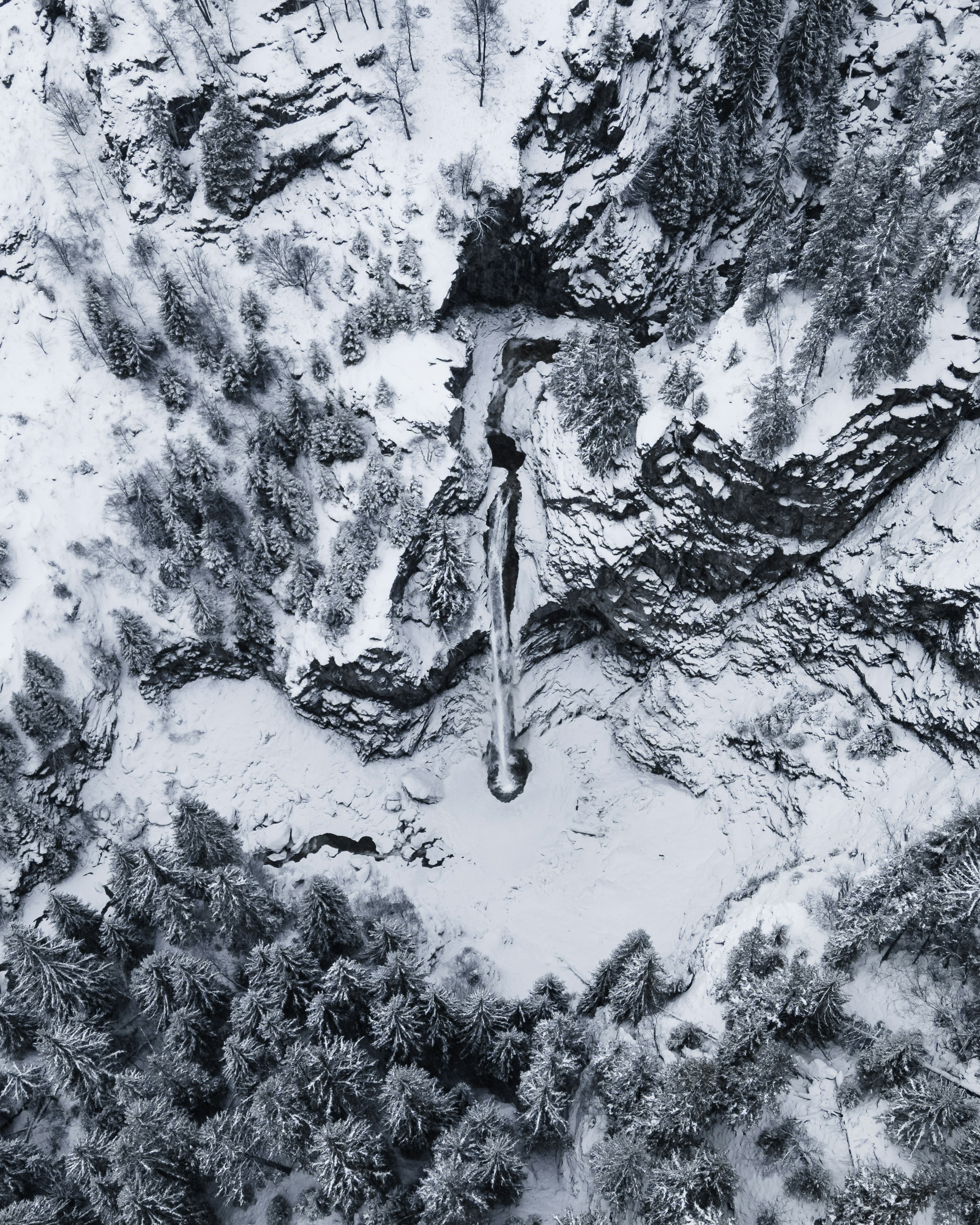 Icy Ribbon Descent: A Narrow Waterfall in a Snowbound Canyon