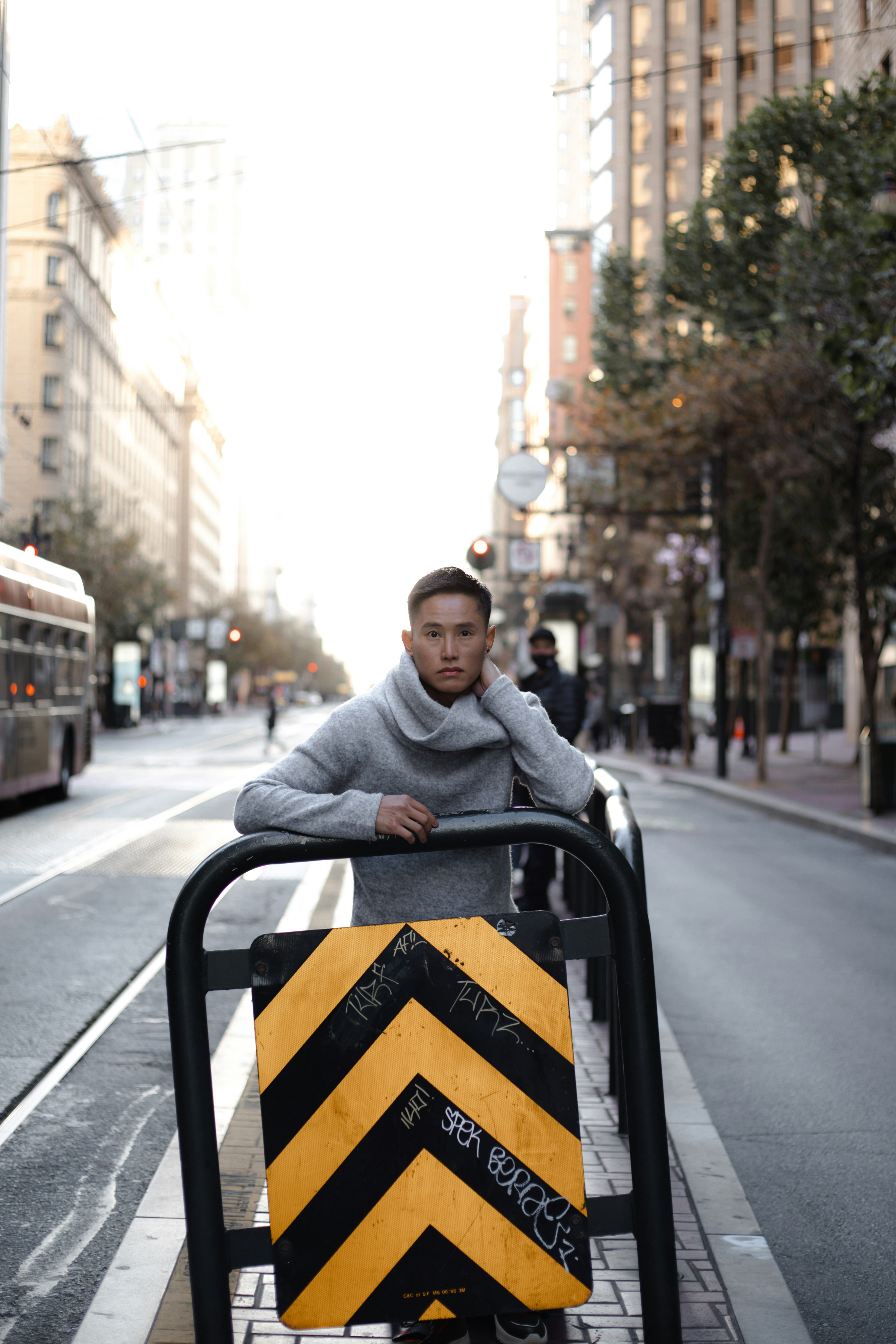 Urban Pause at the Chevron Barrier: A Street Portrait in Motion