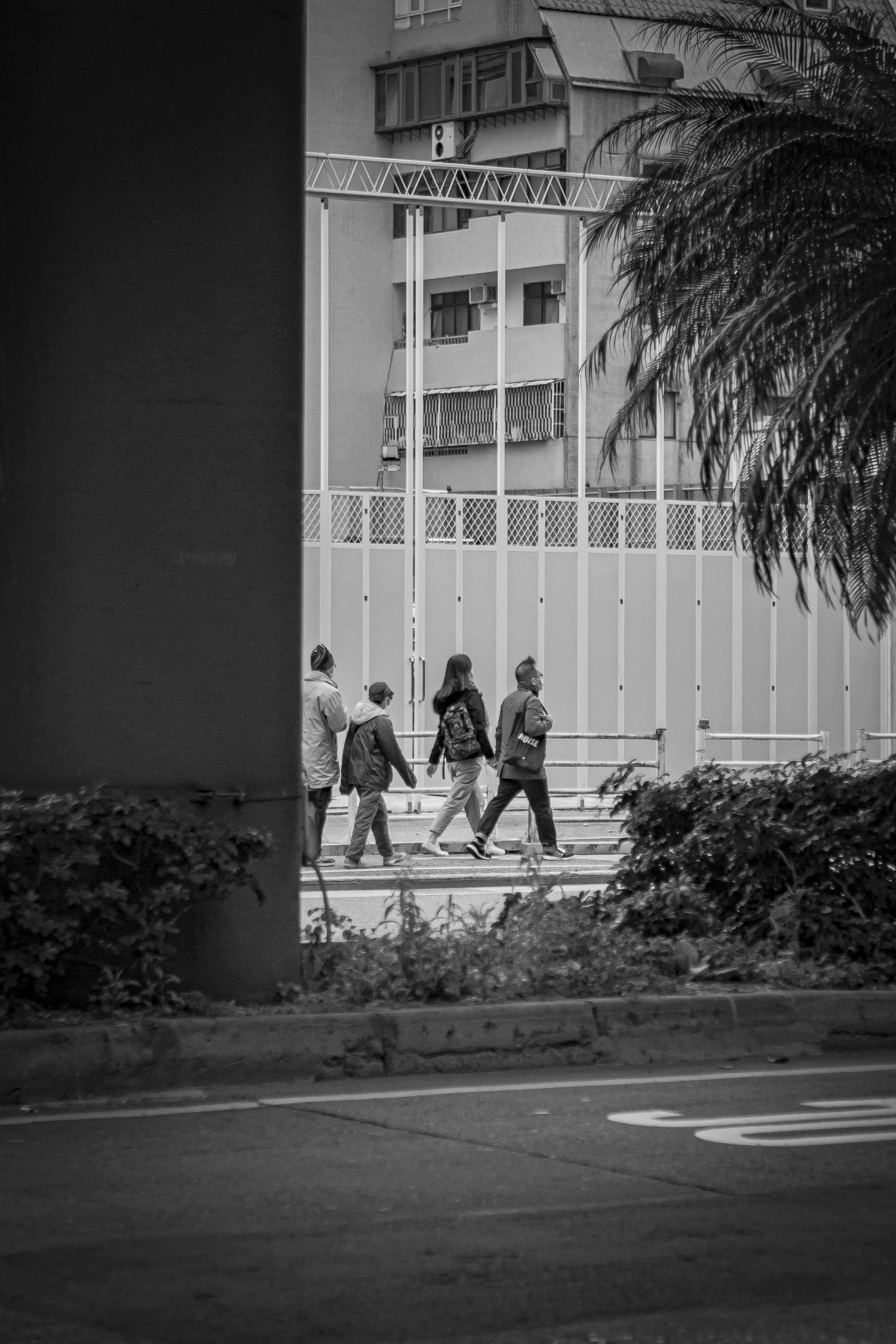 grayscale photo of 2 men and 2 women standing near building
