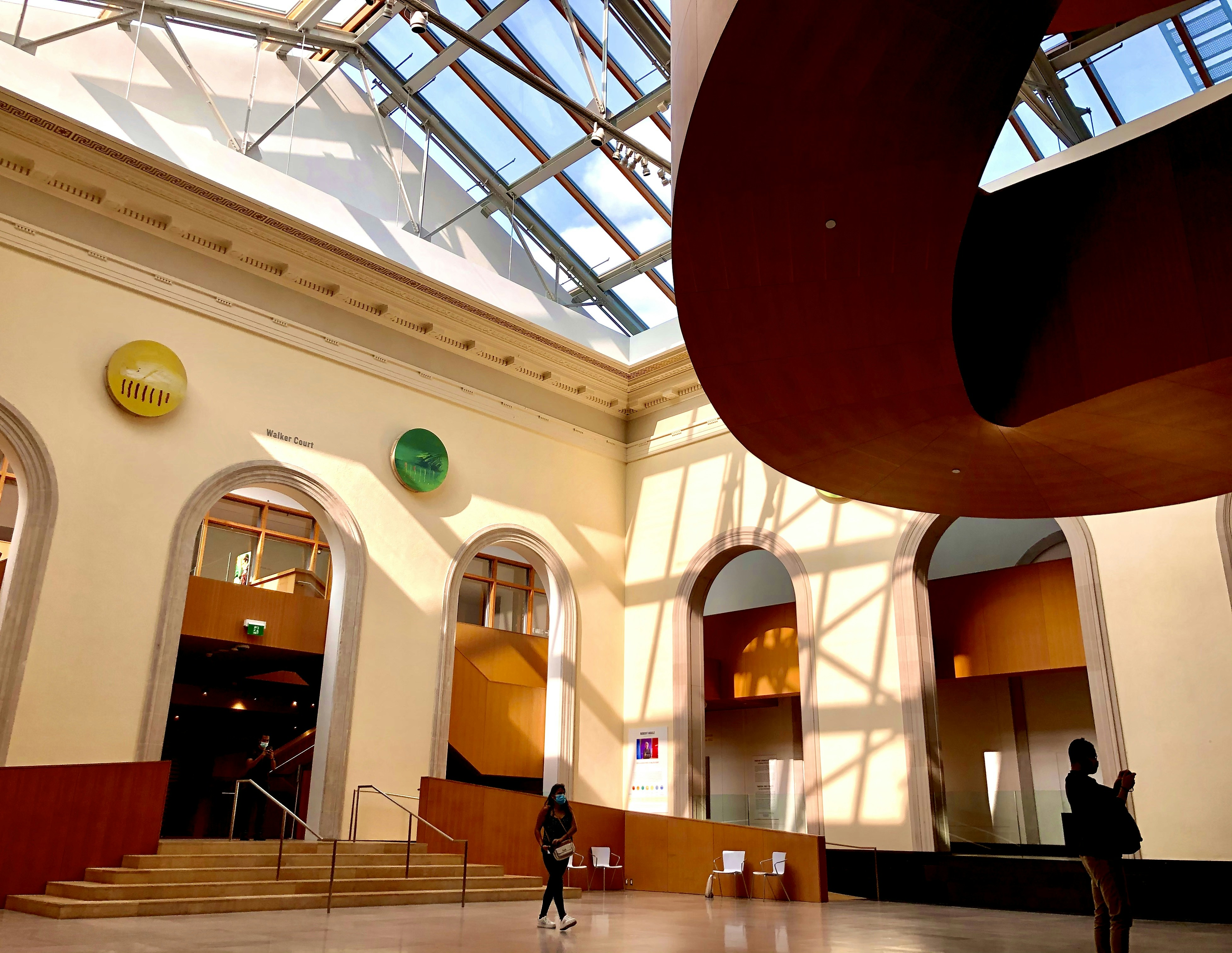 Two people walking in a large building with a skylight photo – Free ...