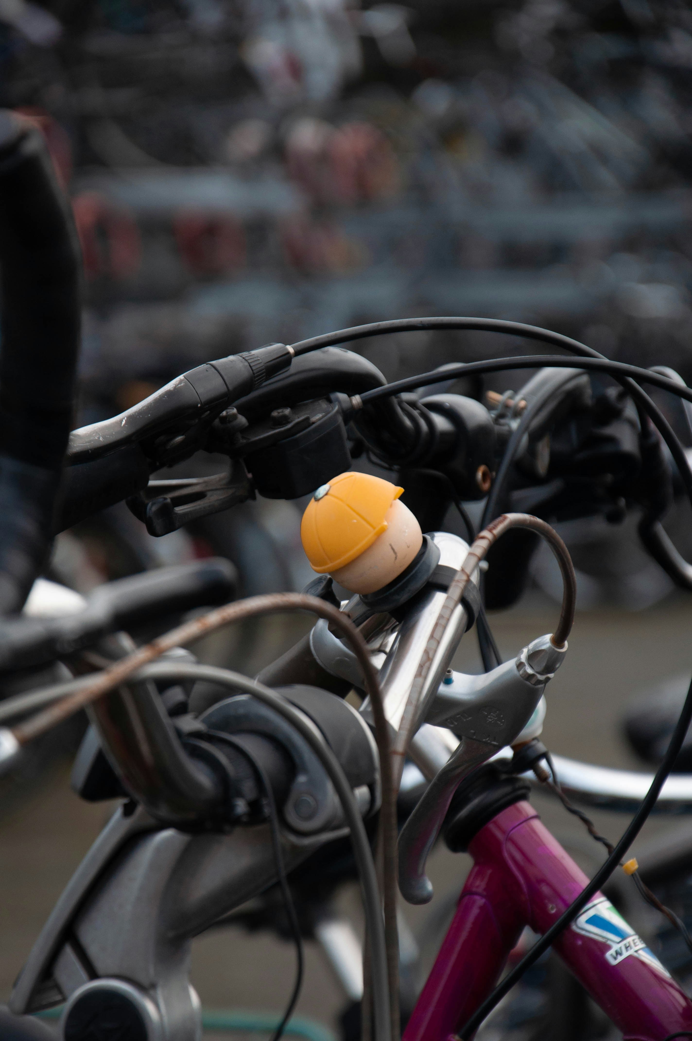 Bright orange bike cap anchors the chaotic tangle of handlebars