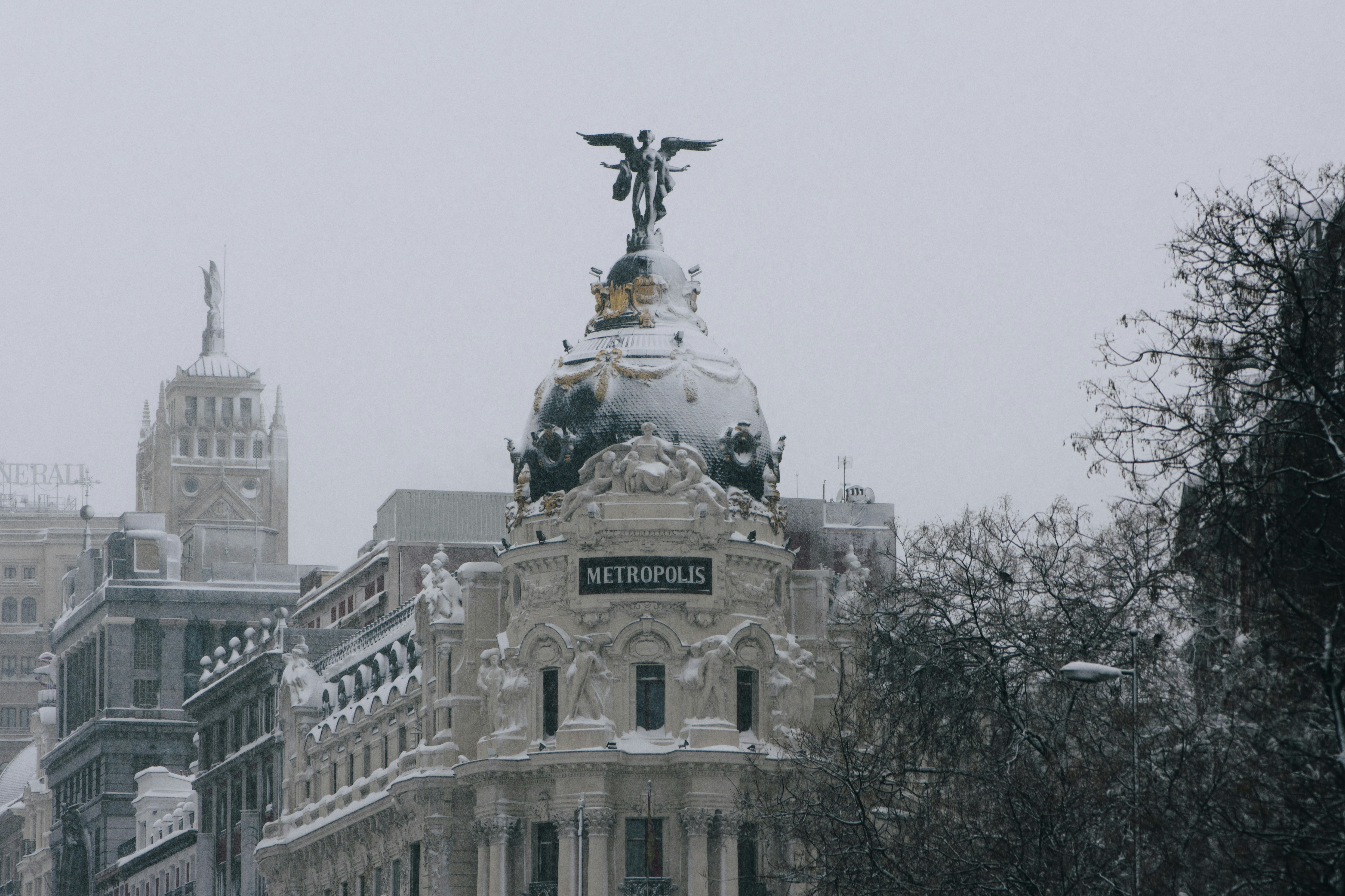 The iconic Metropolis building adorned with snow, standing majestically amidst a winter cityscape. A symbol of architectural beauty in a serene, snowy atmosphere.