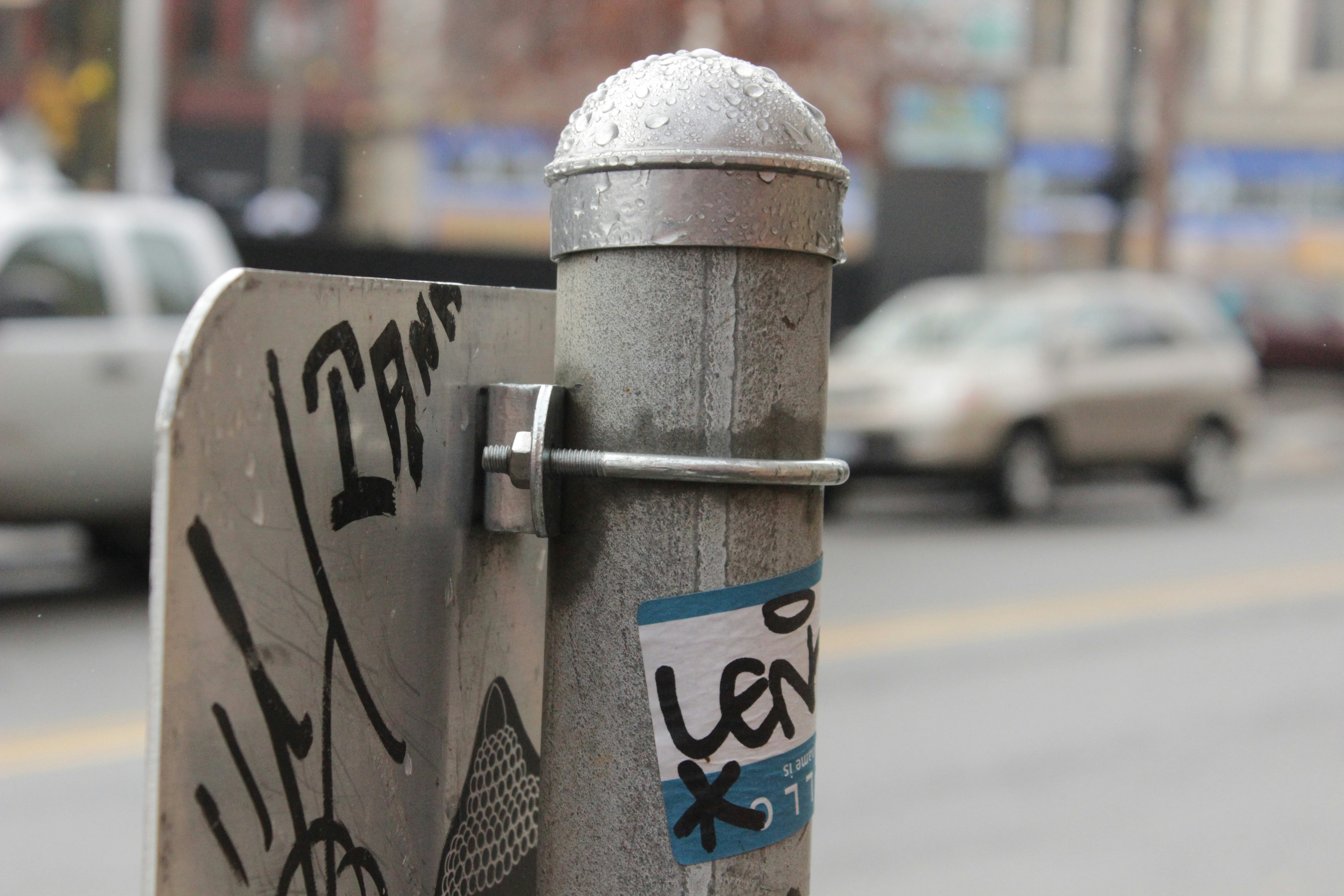 Rain-kissed Urban Post: A Close-Up of a Weathered Street Post
