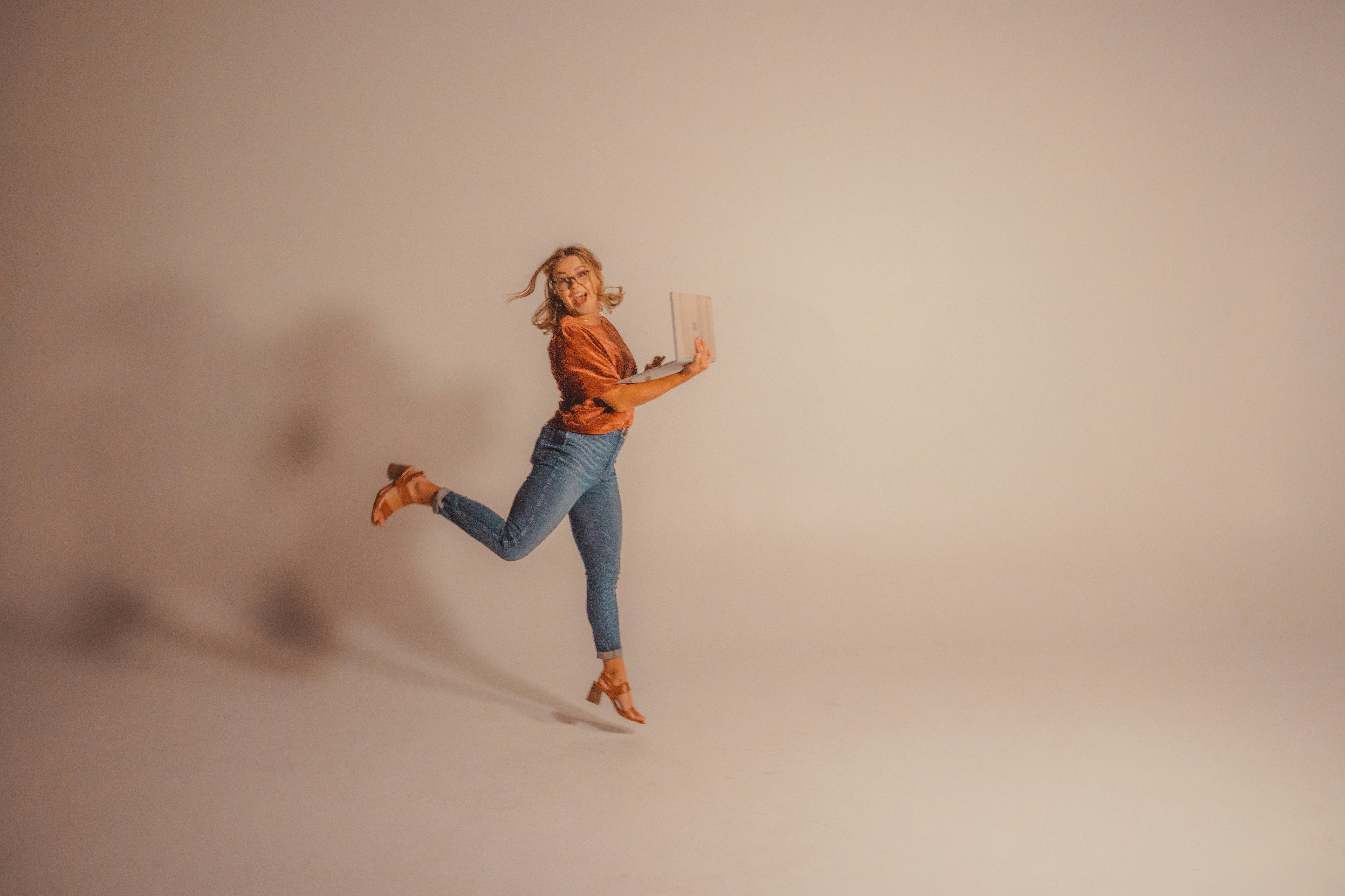 woman in blue denim jeans and brown jacket jumping