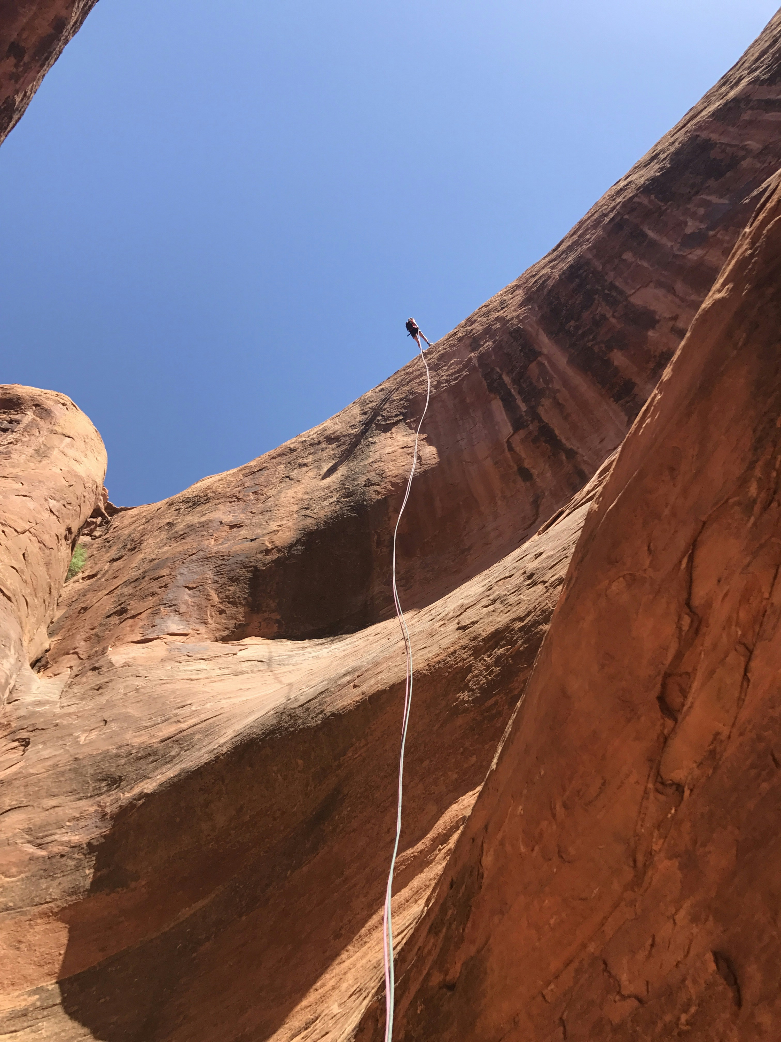 Crimson Canyon Ascent: A Lone Climber Clings to the Sky