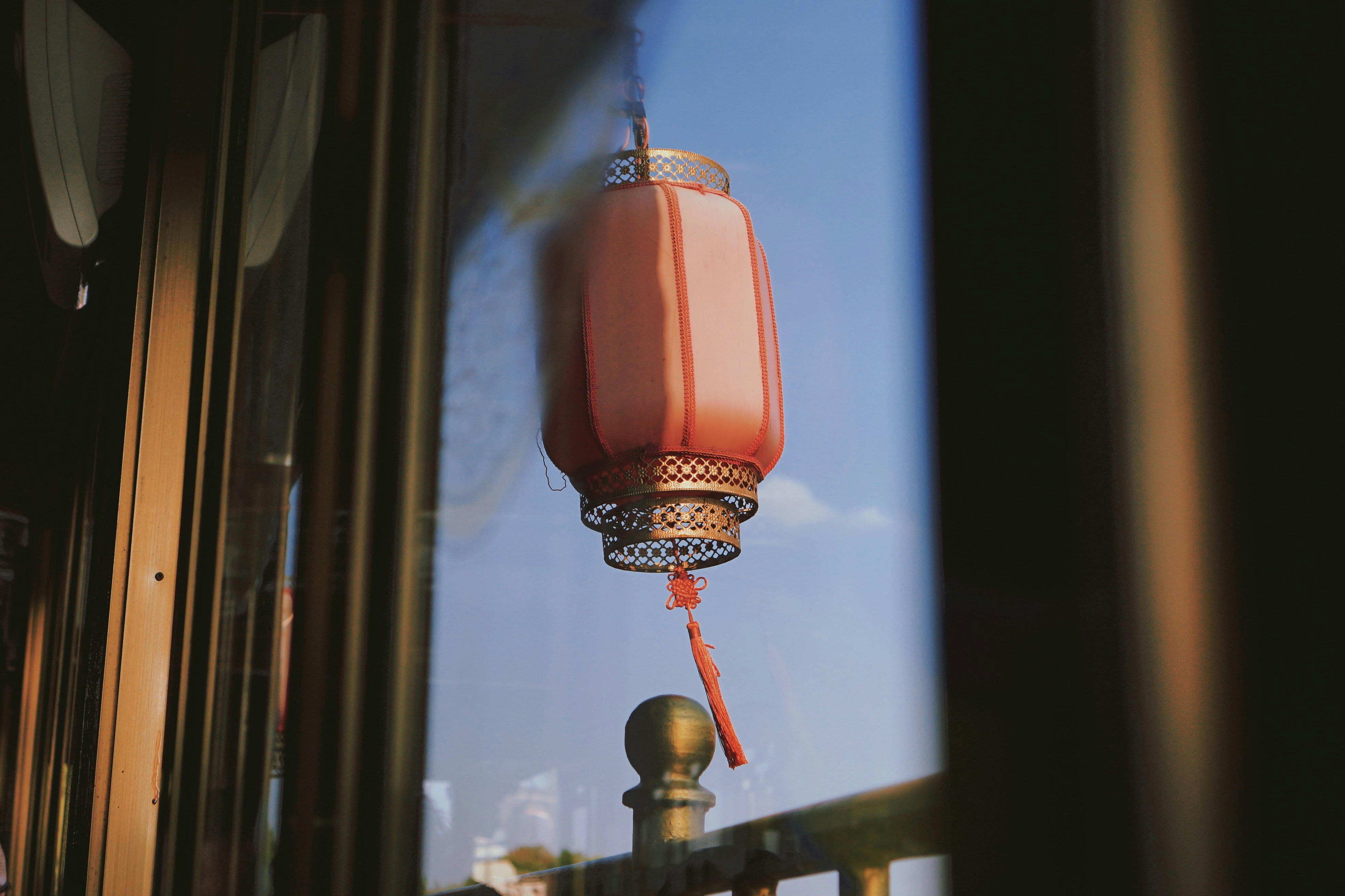 Crimson Lantern Framed by Glass and Sky