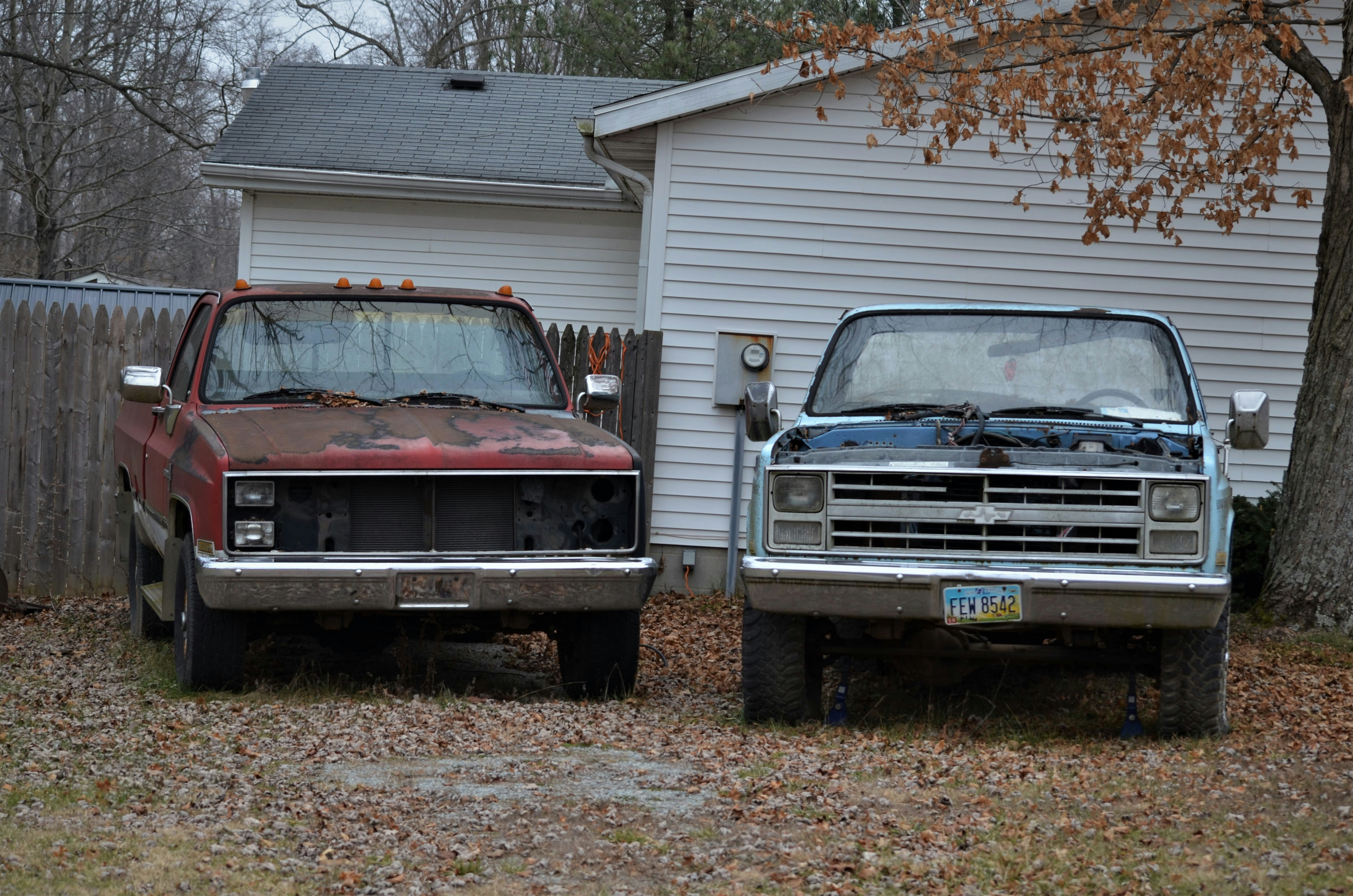 Red chevrolet car parked beside white wooden house during daytime photo ...