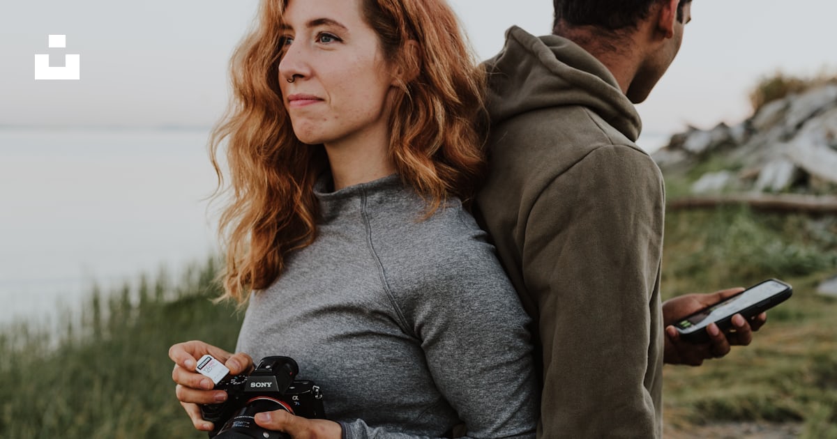 Foto Mujer Con Sudadera Con Capucha Gris Sosteniendo Una Cámara Dslr