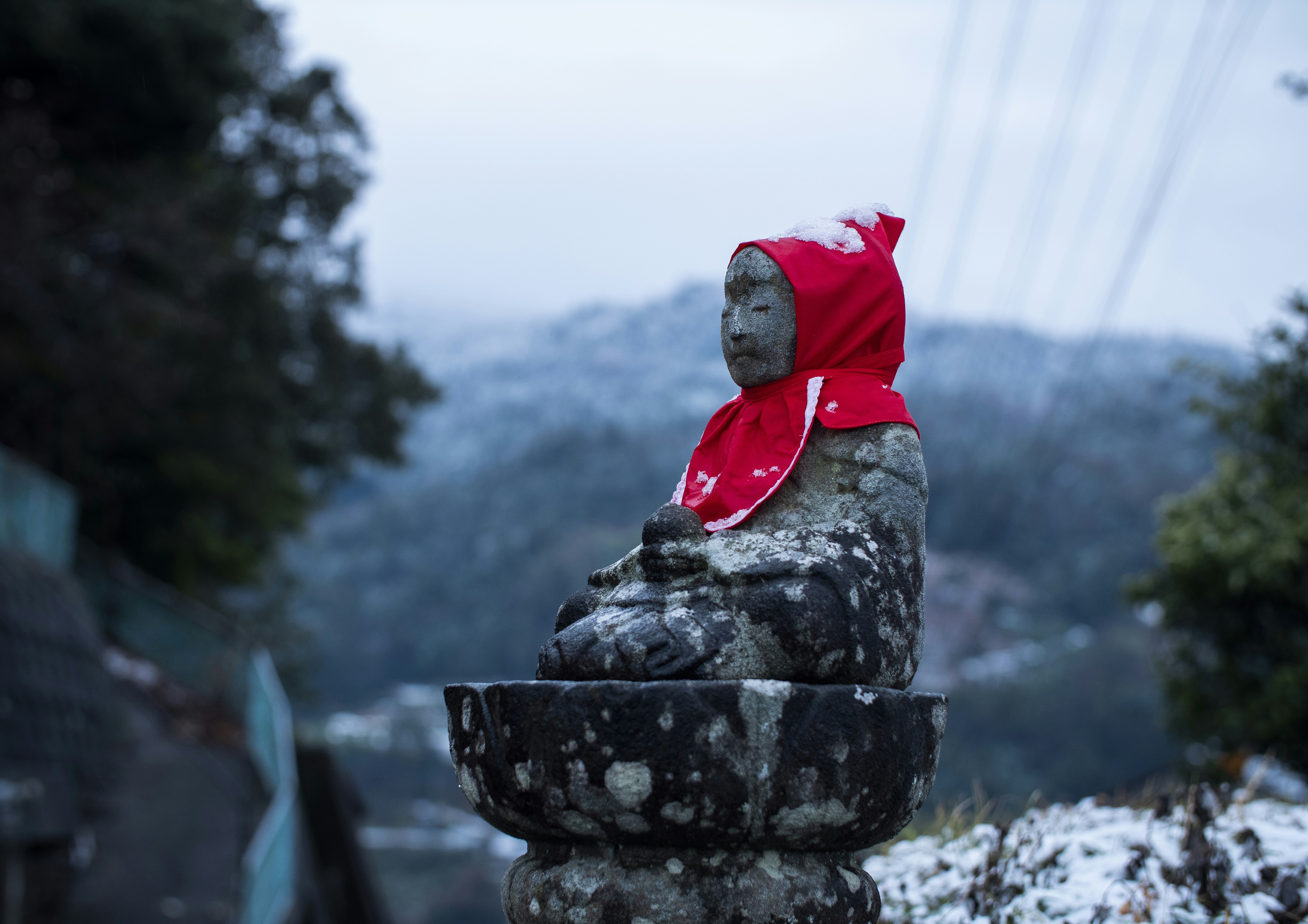 Scarlet Hood in Silent Snow: A Stone Guardian Overlooking the Valley