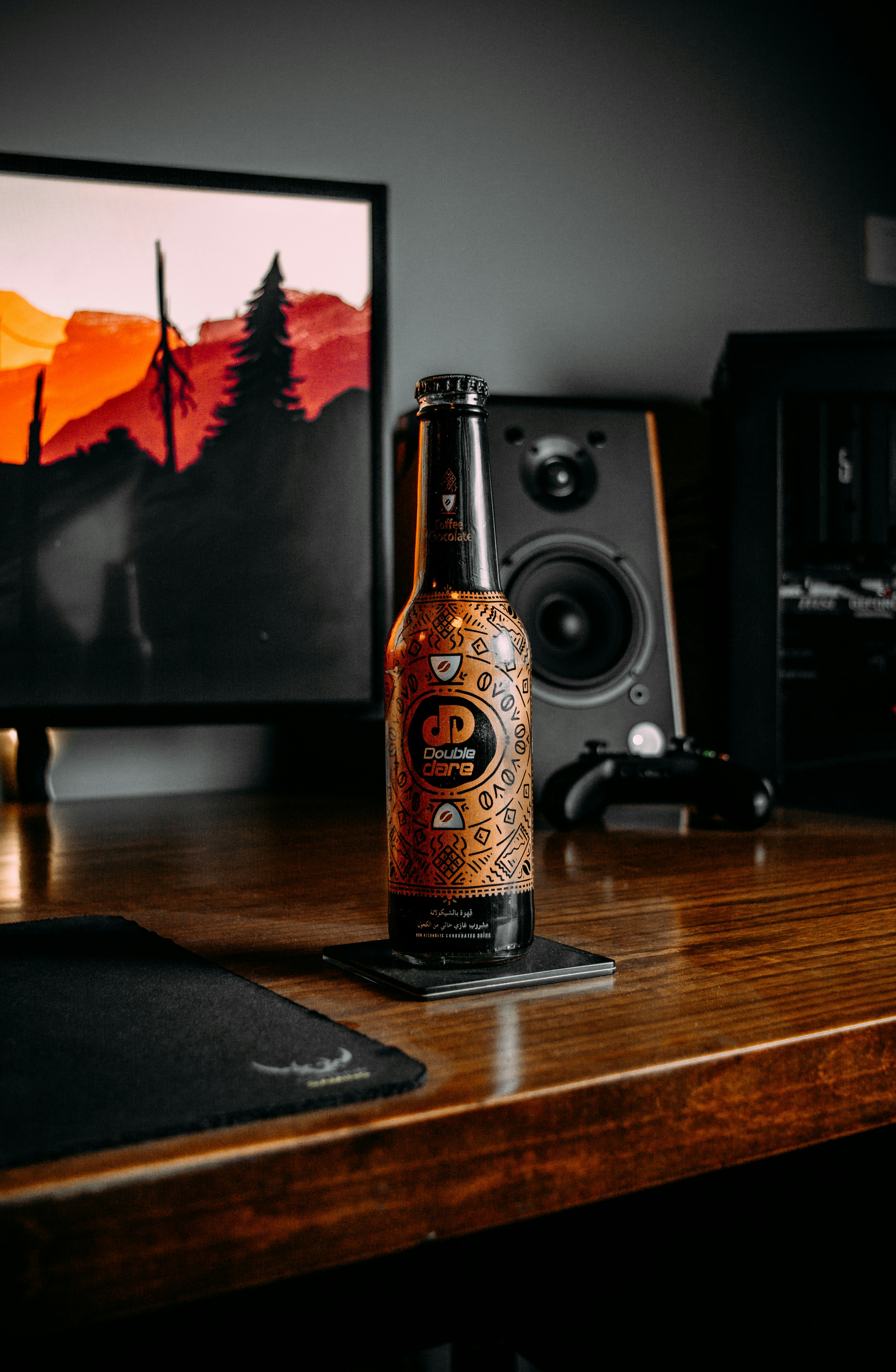 Amber Bottle Anchors a Moody Desk Scene Under Studio Monitors