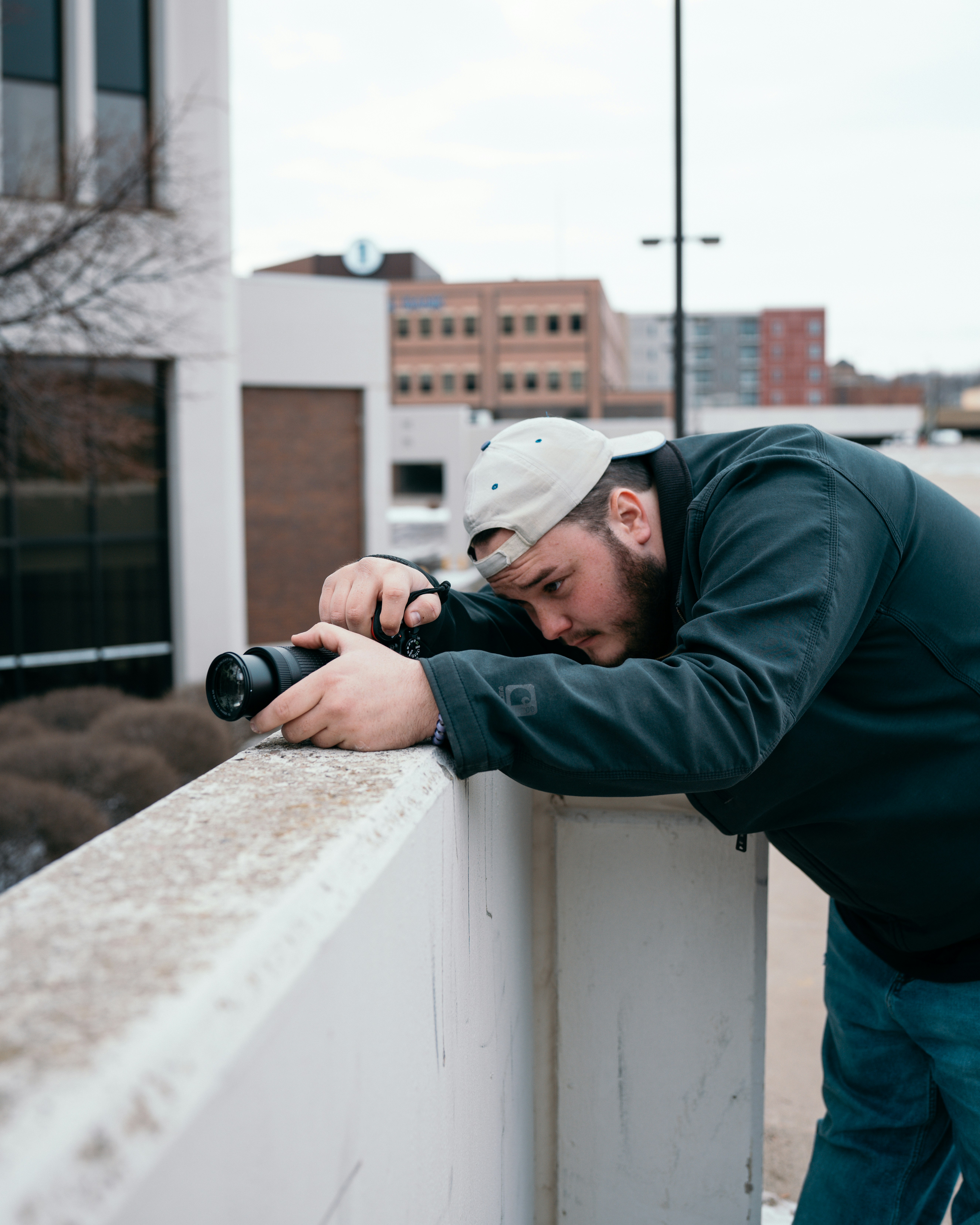 Edge of Focus: Rooftop Portrait of a Photographer in Concentration