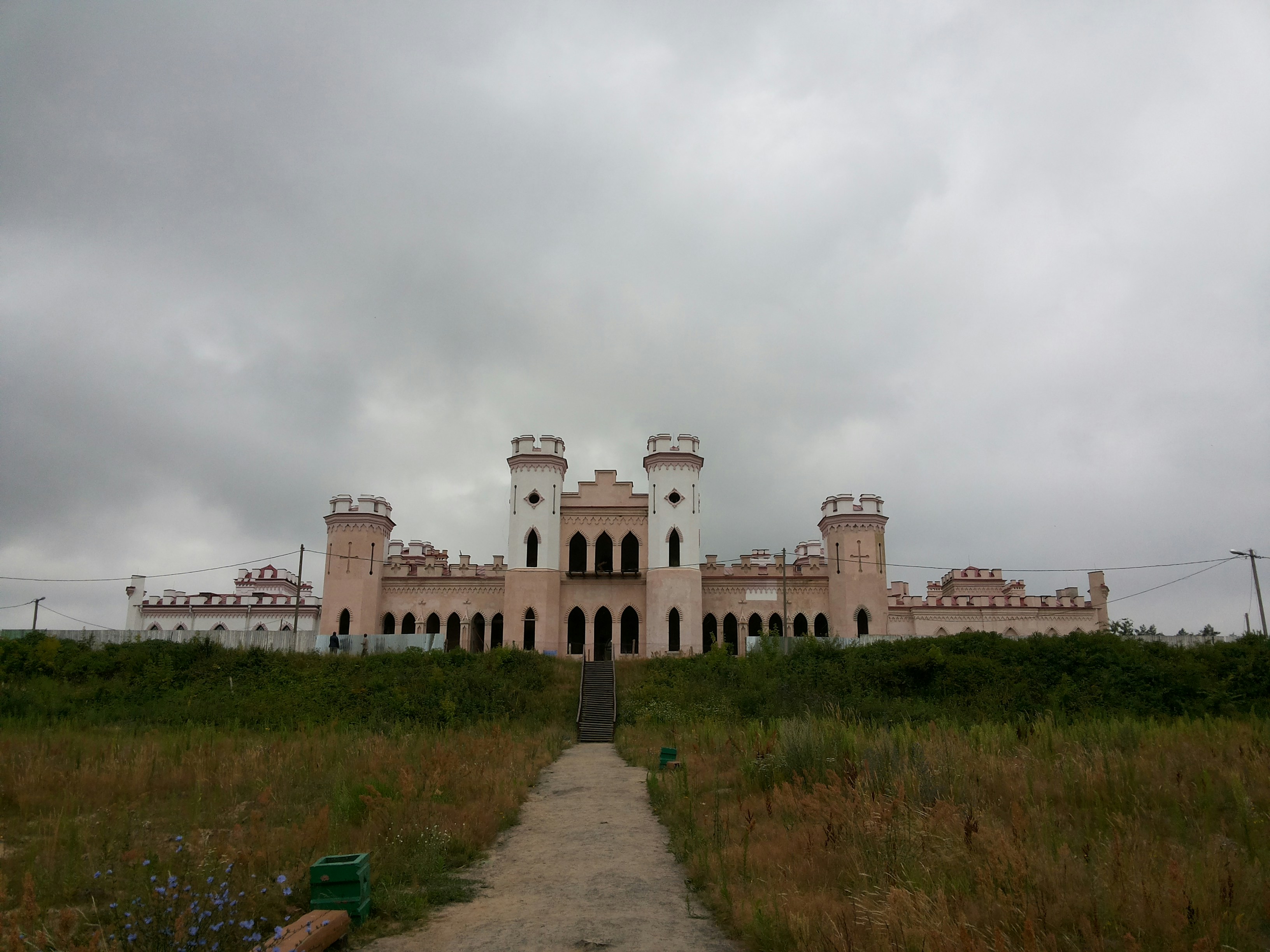 Gateway on the Grassland: Pale Fortress under a Clouded Sky