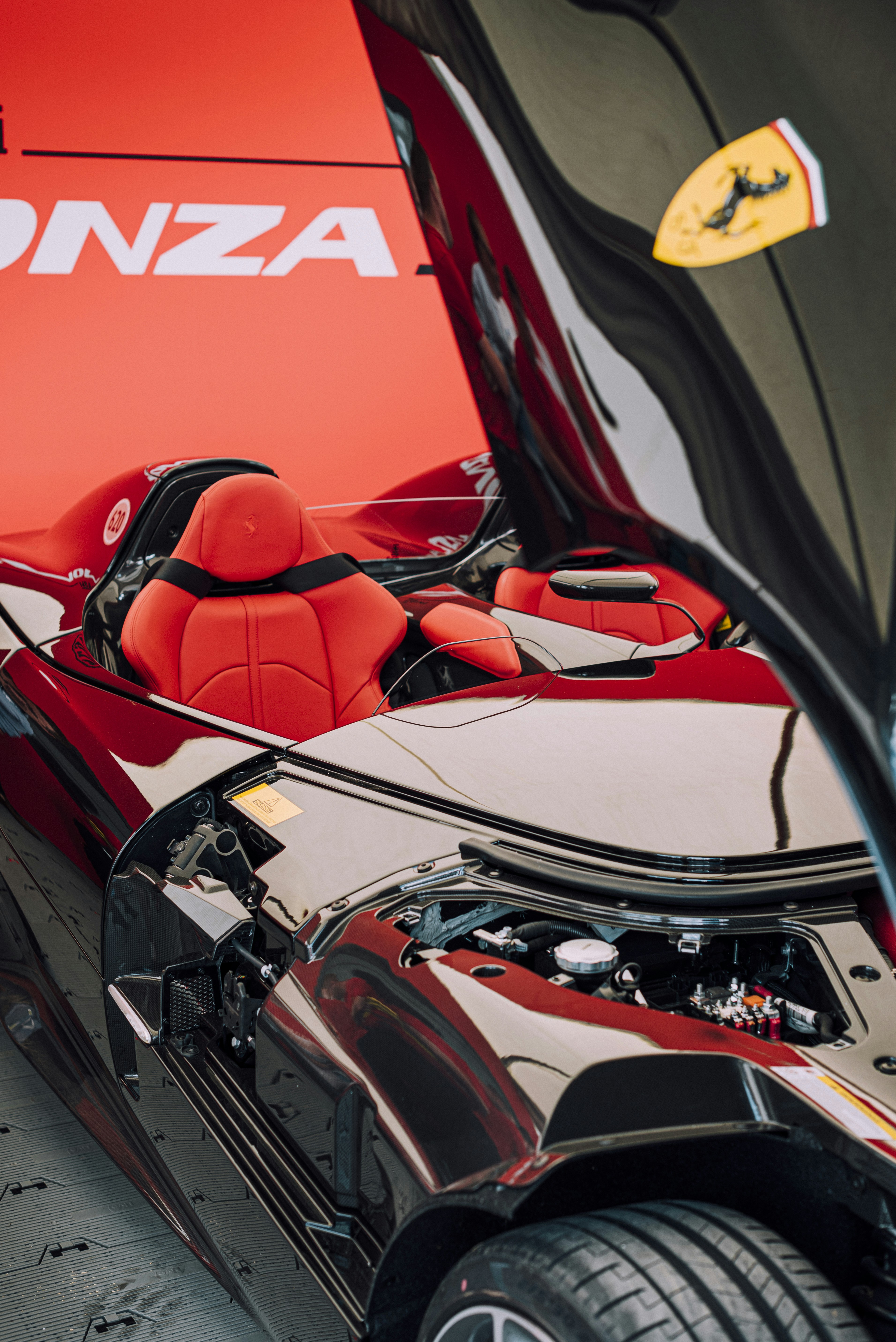 Red and black interior of a Ferrari Monza SP2 with a focus on sleek design and glossy finishes.