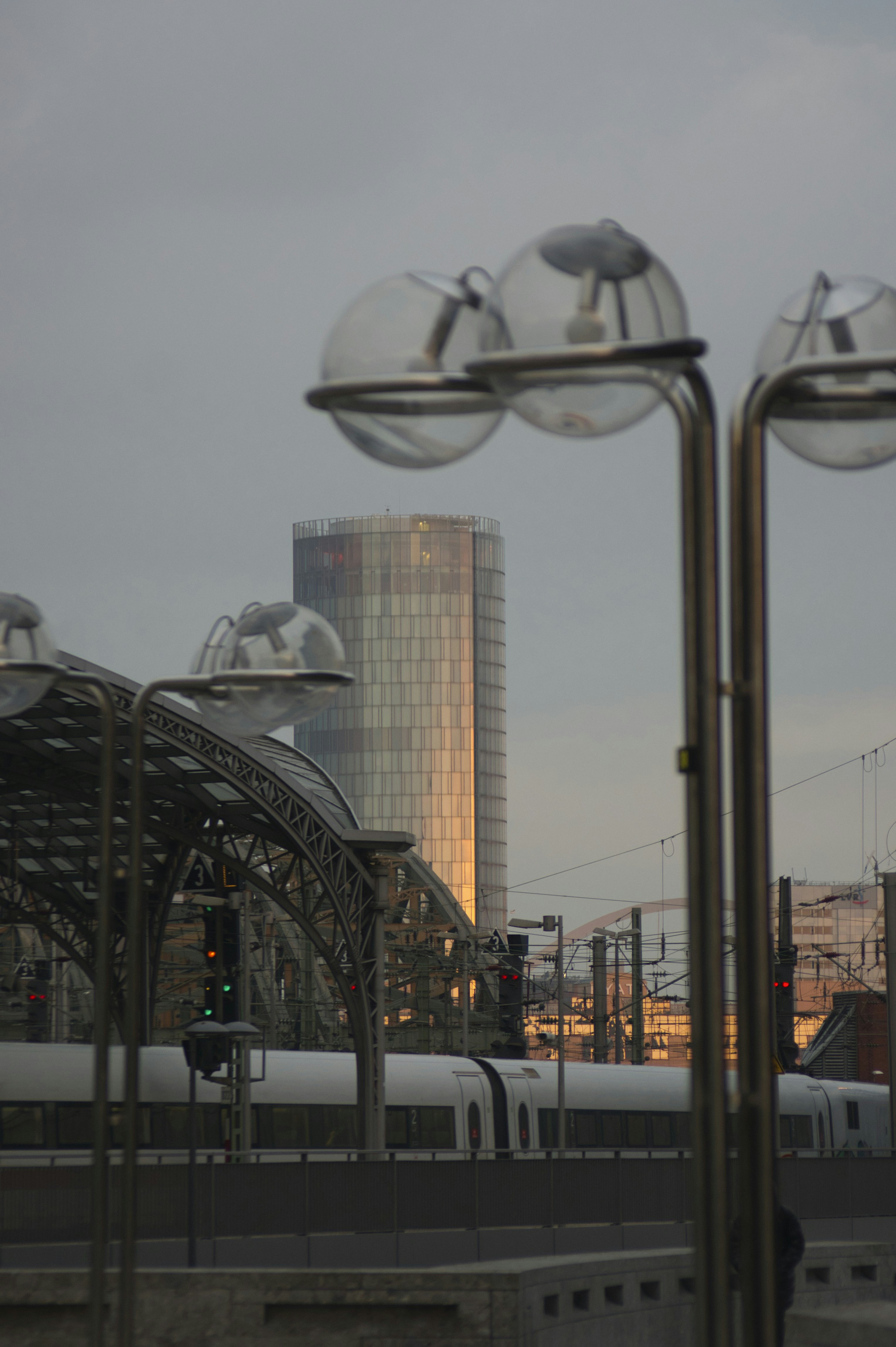 Sunlit Glass Tower Rising Behind a Train Yard