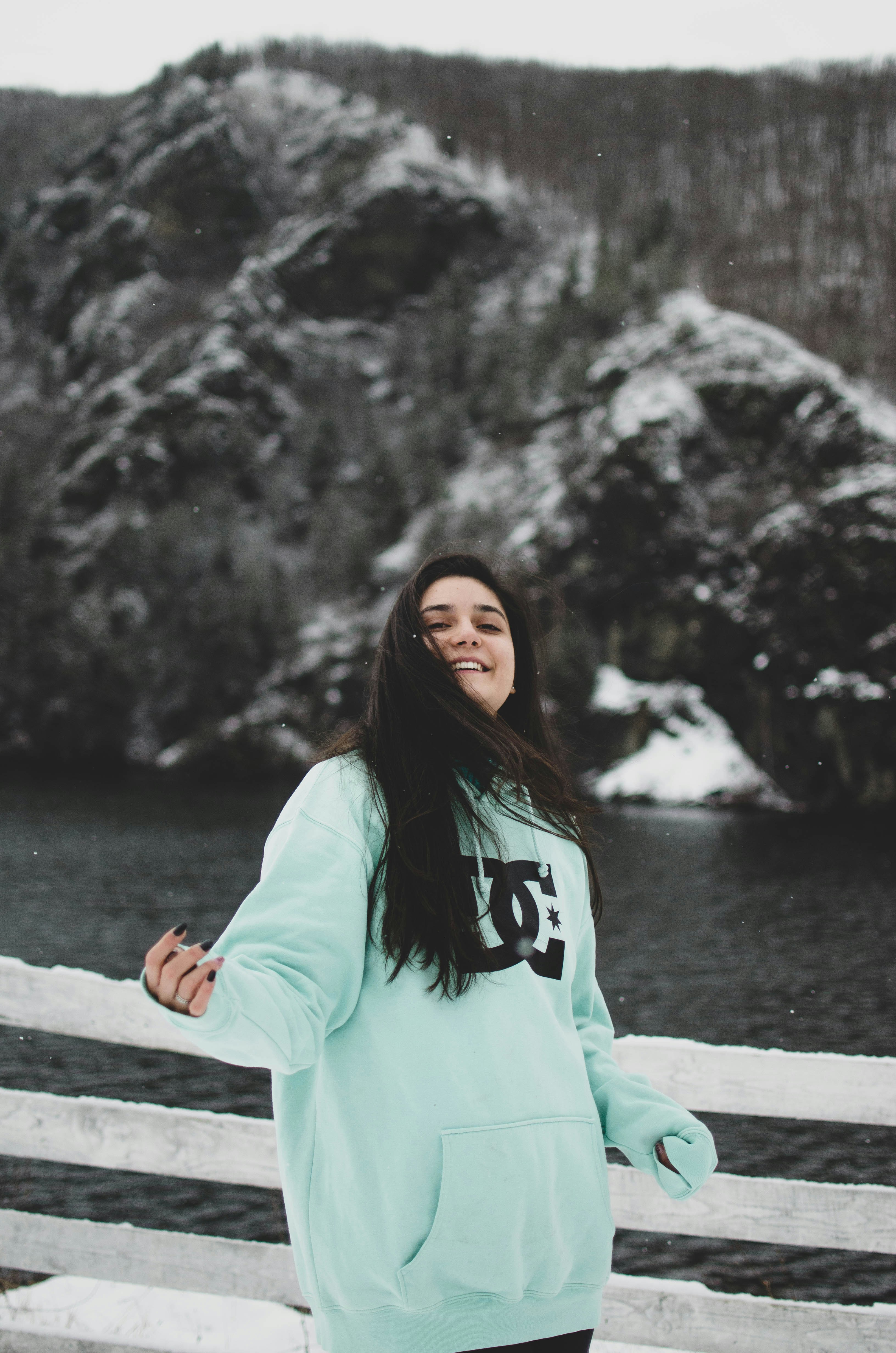 Snowy Gaze Over the River: Youthful Joy in a Turquoise Hoodie